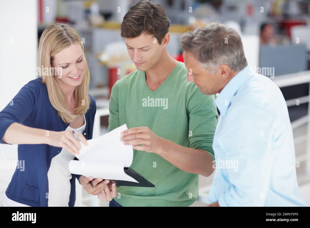 Making some last minute adjustments. Three work colleagues discussing ...