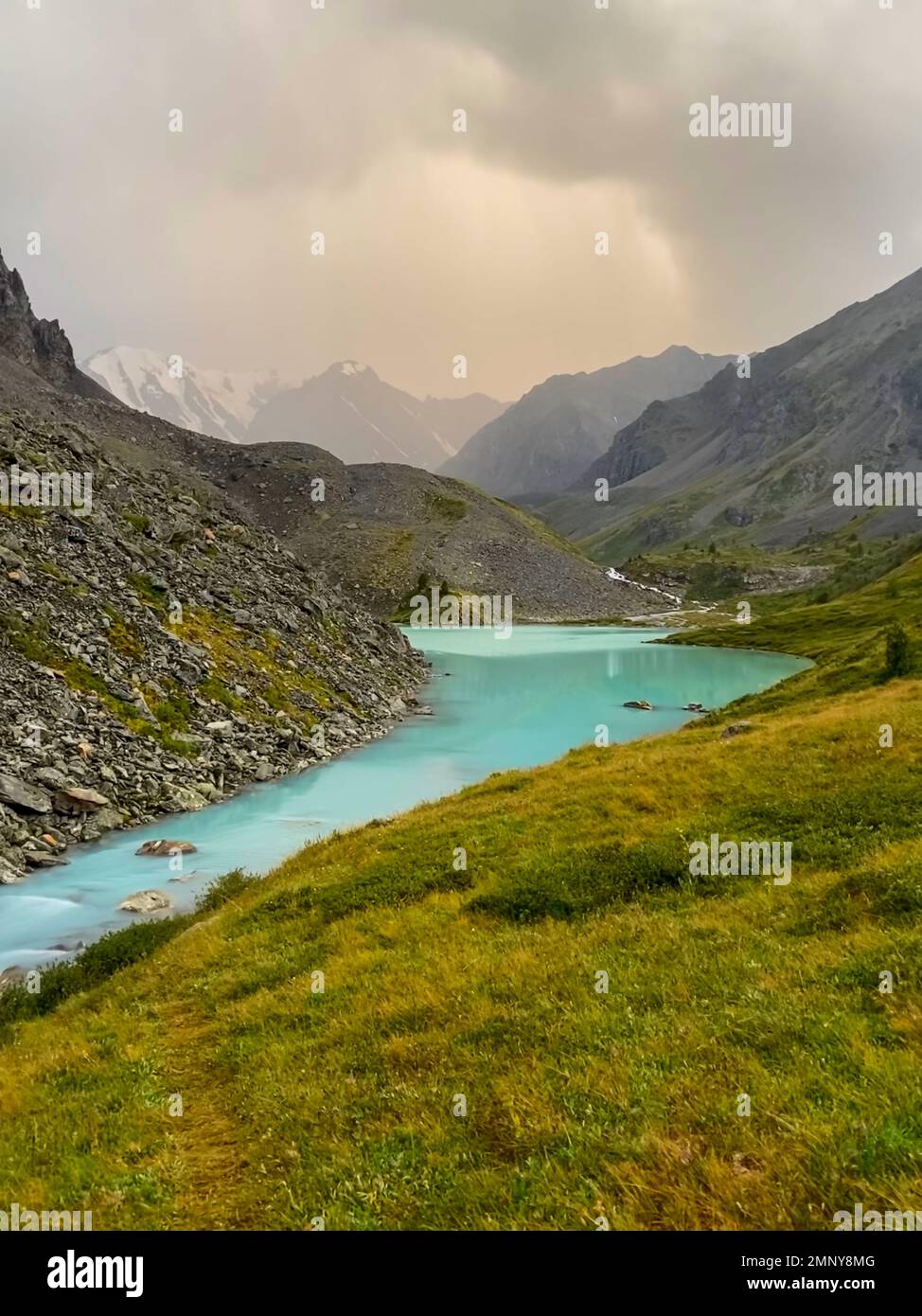 Turquoise transparent water of Karakabak flows out of the lake among ...