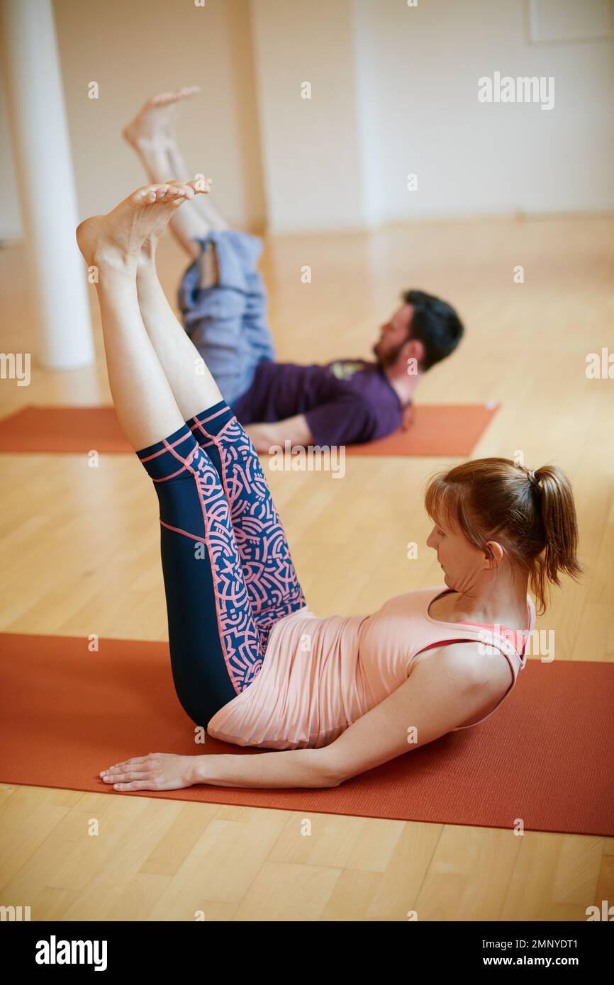 Staying in shape with daily yoga. two people doing yoga together in a ...