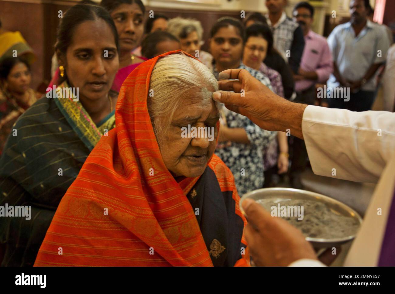 An Indian Catholic priest marks cross symbol on the forehead of ...