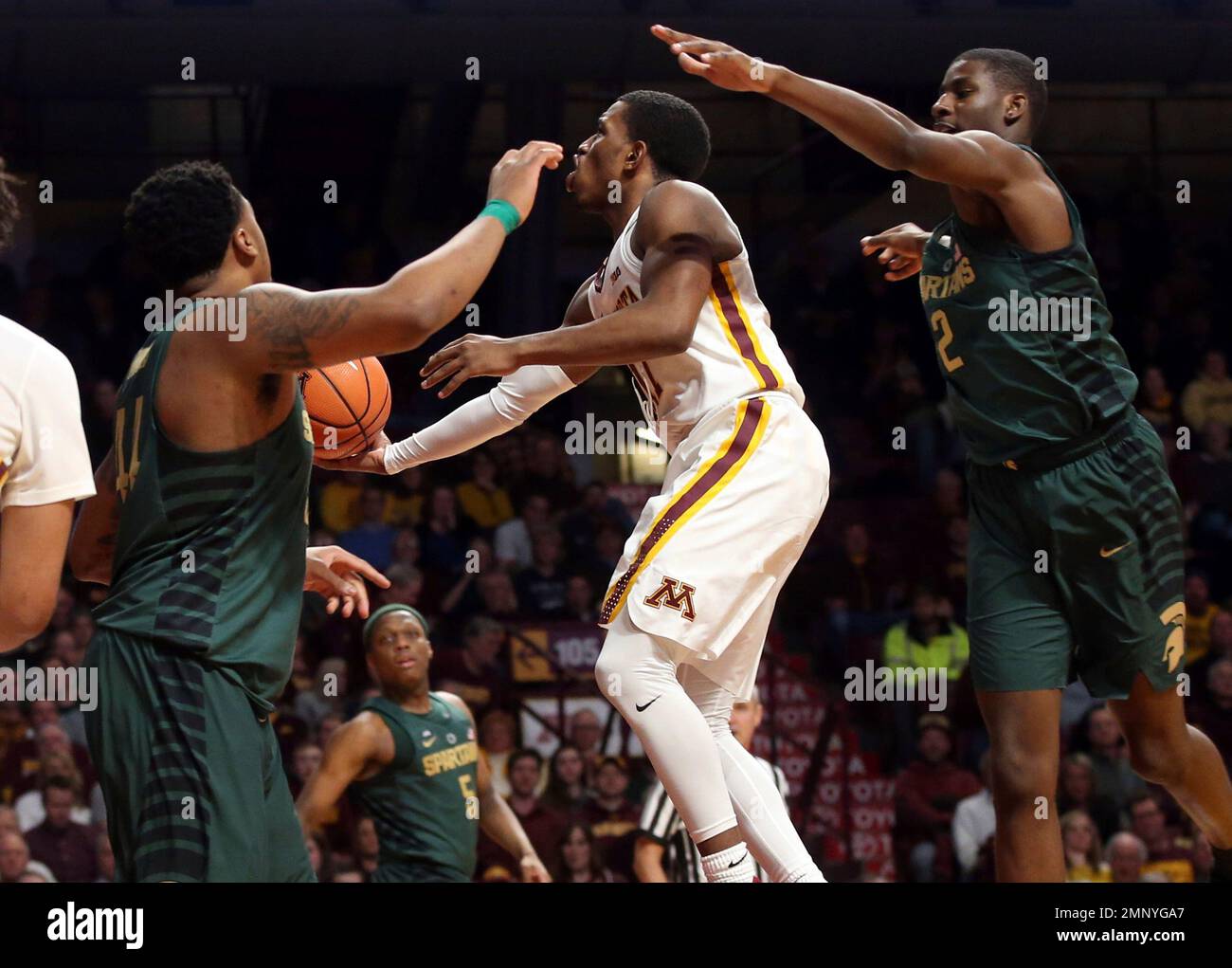 Minnesota's Isaiah Washington, center, shoots between Michigan State's ...