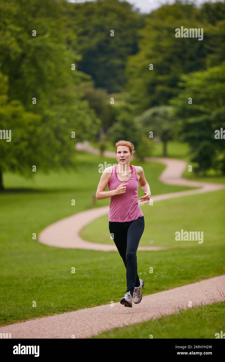 Keep putting one foot in front of the other. a woman jogging along a ...