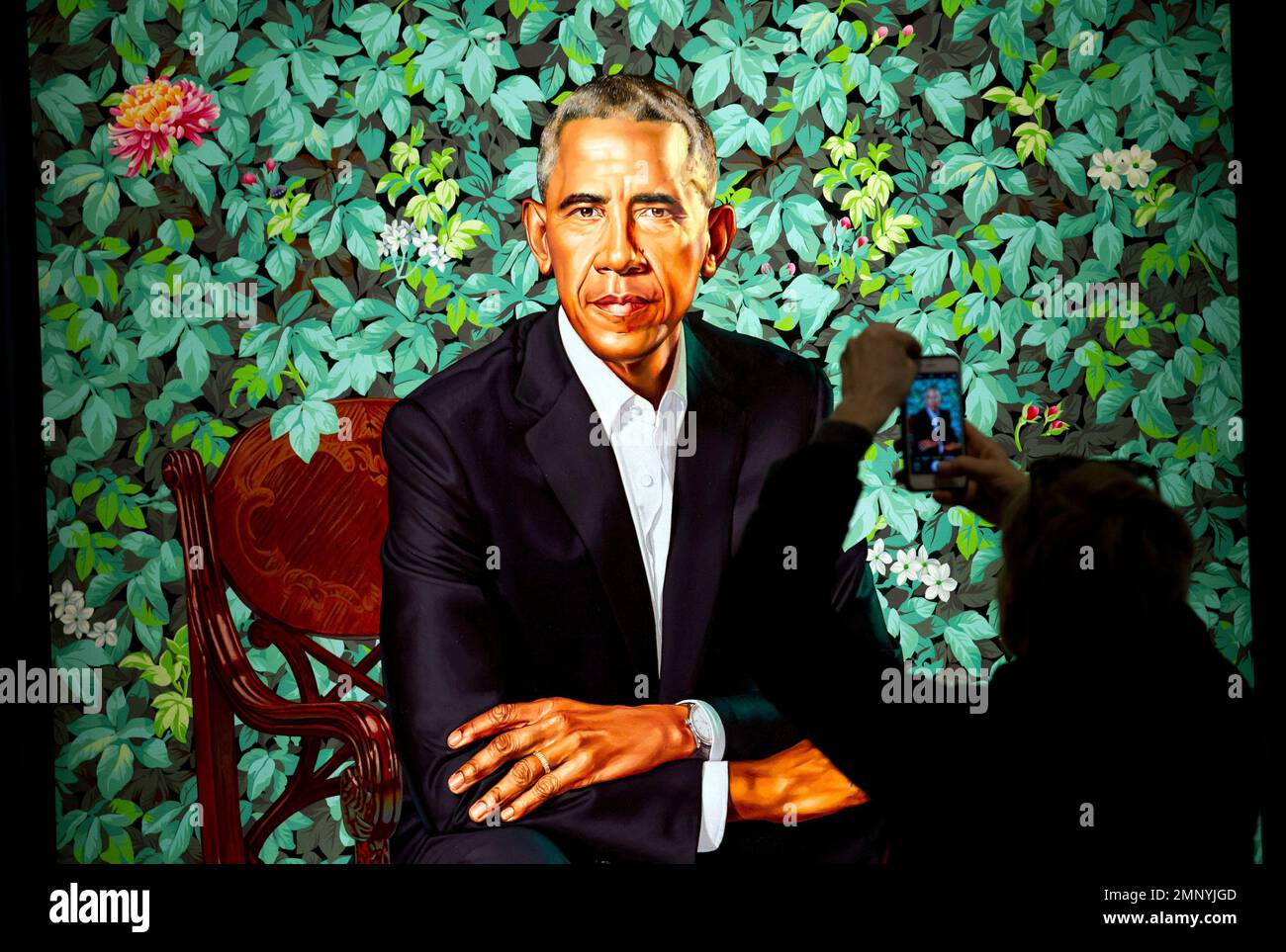 A visitors take picture of the official portrait of the former ...