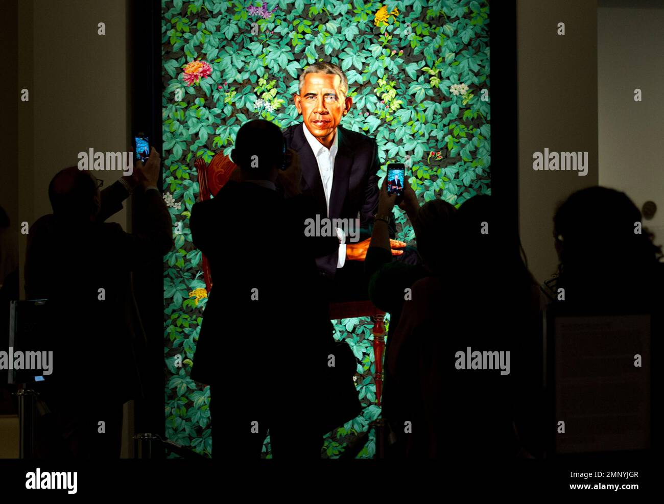 Visitors take pictures of the official portrait of the former President ...