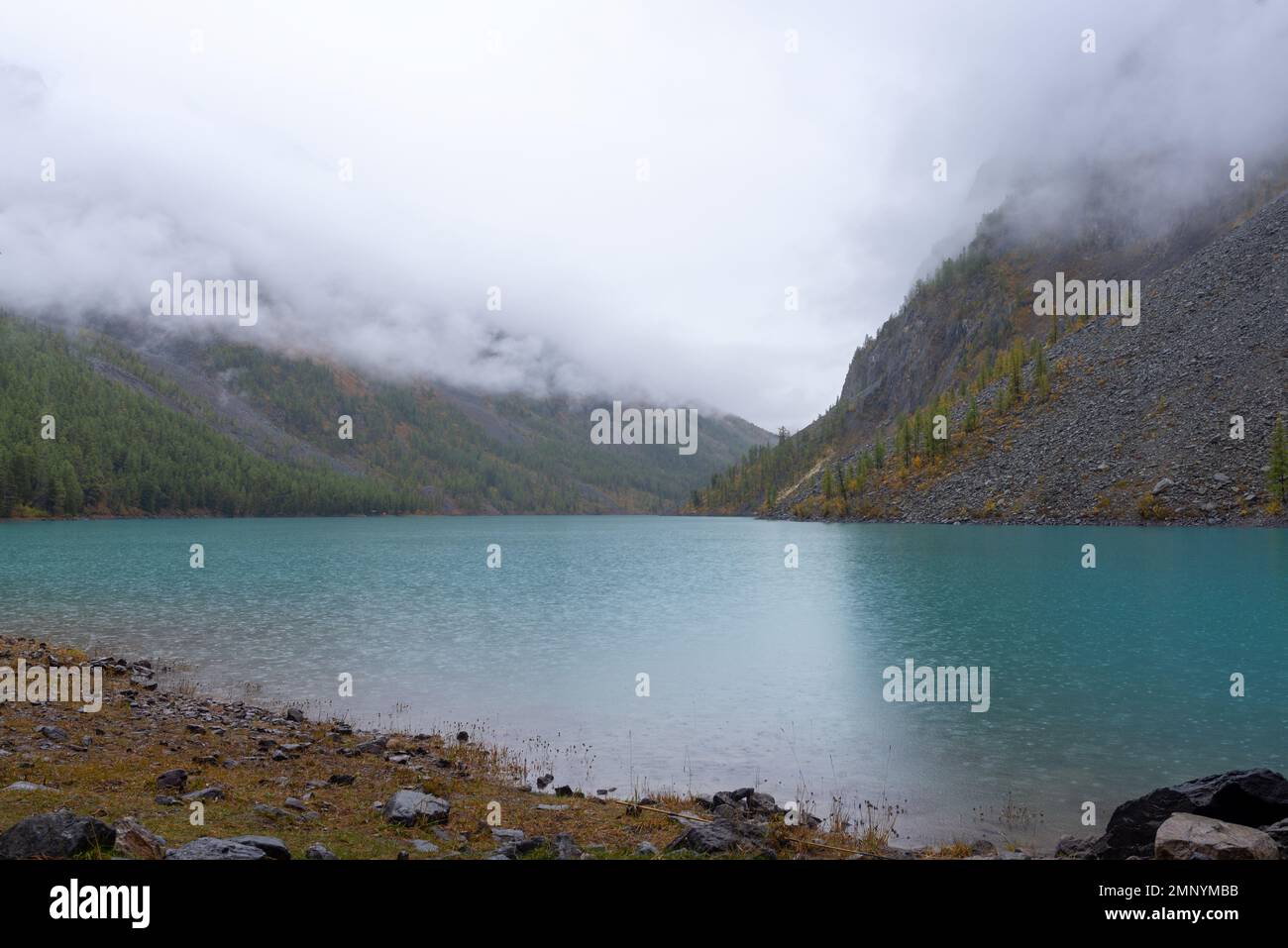 The rain falls on the mountain turquoise lake Shavlinskoe among the ...