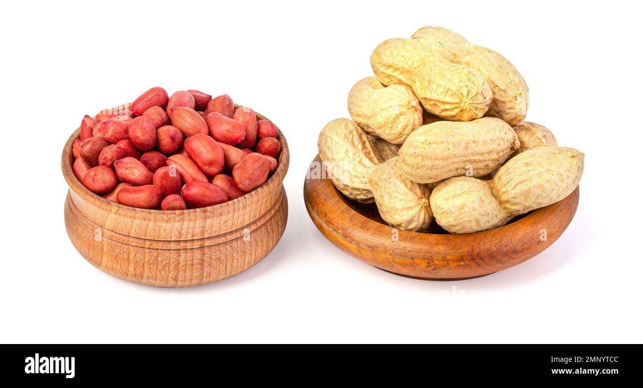 Dried peanuts in the peel and peeled close-up in wooden bowls on a ...