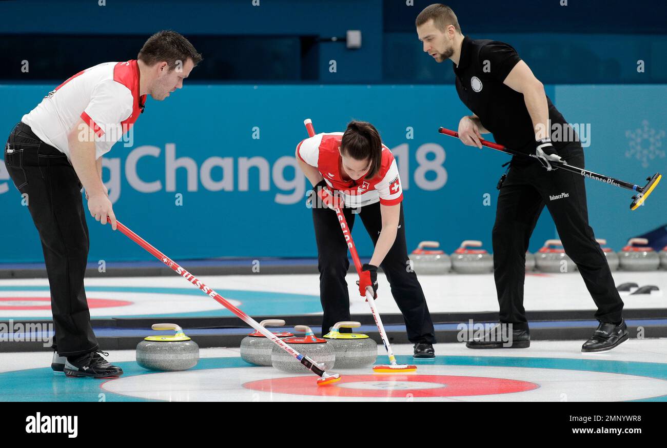 Switzerland Martin Rios, left, and Jenny Perret, center, sweep ice as ...