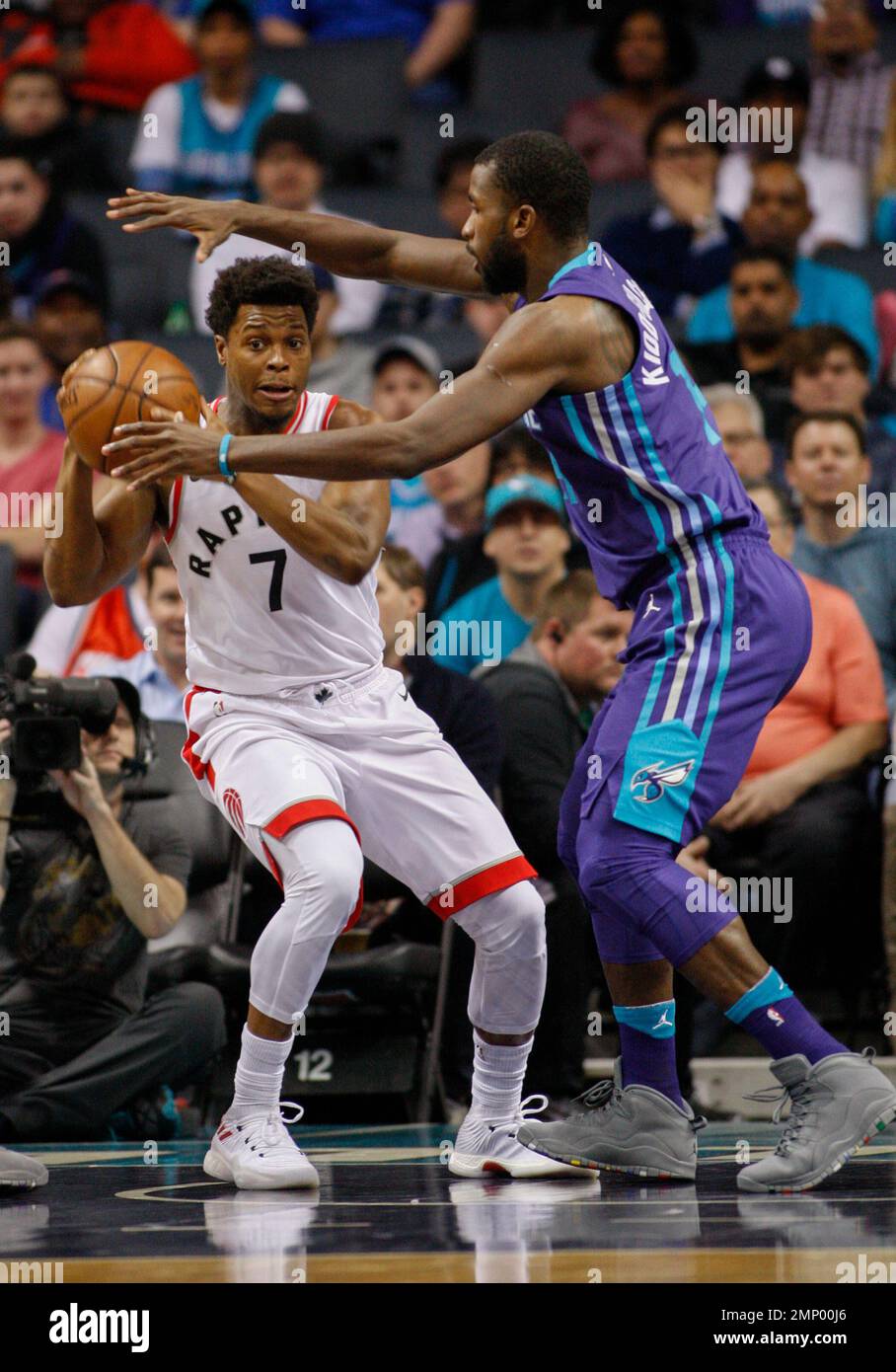 Toronto Raptors guard Kyle Lowry, left, tries to pass around Charlotte ...