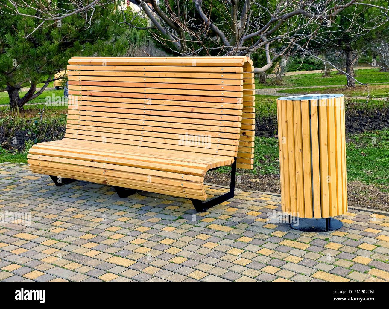 Modern wooden benches standing on the sides of the paved paths of the ...