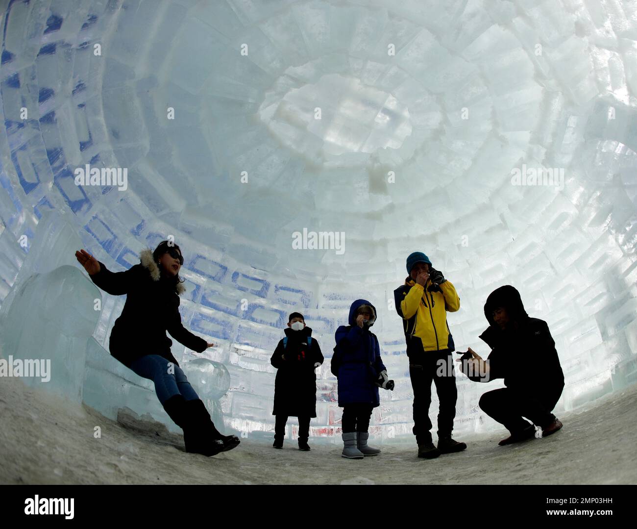 People stand inside an igloo built as part of the festivities for the ...