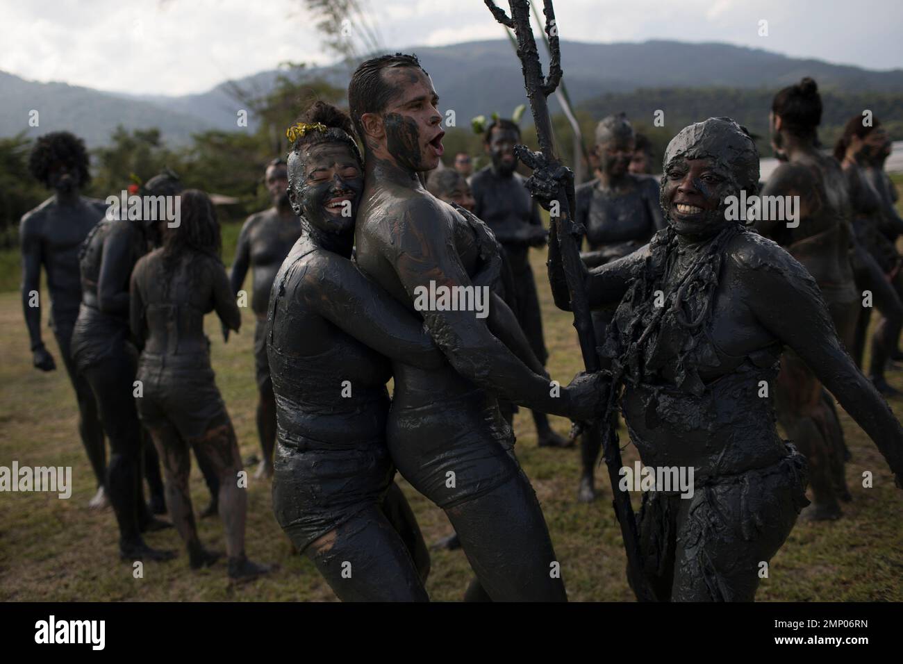 People covered in mud dance during the traditional "Bloco da Lama" or ...
