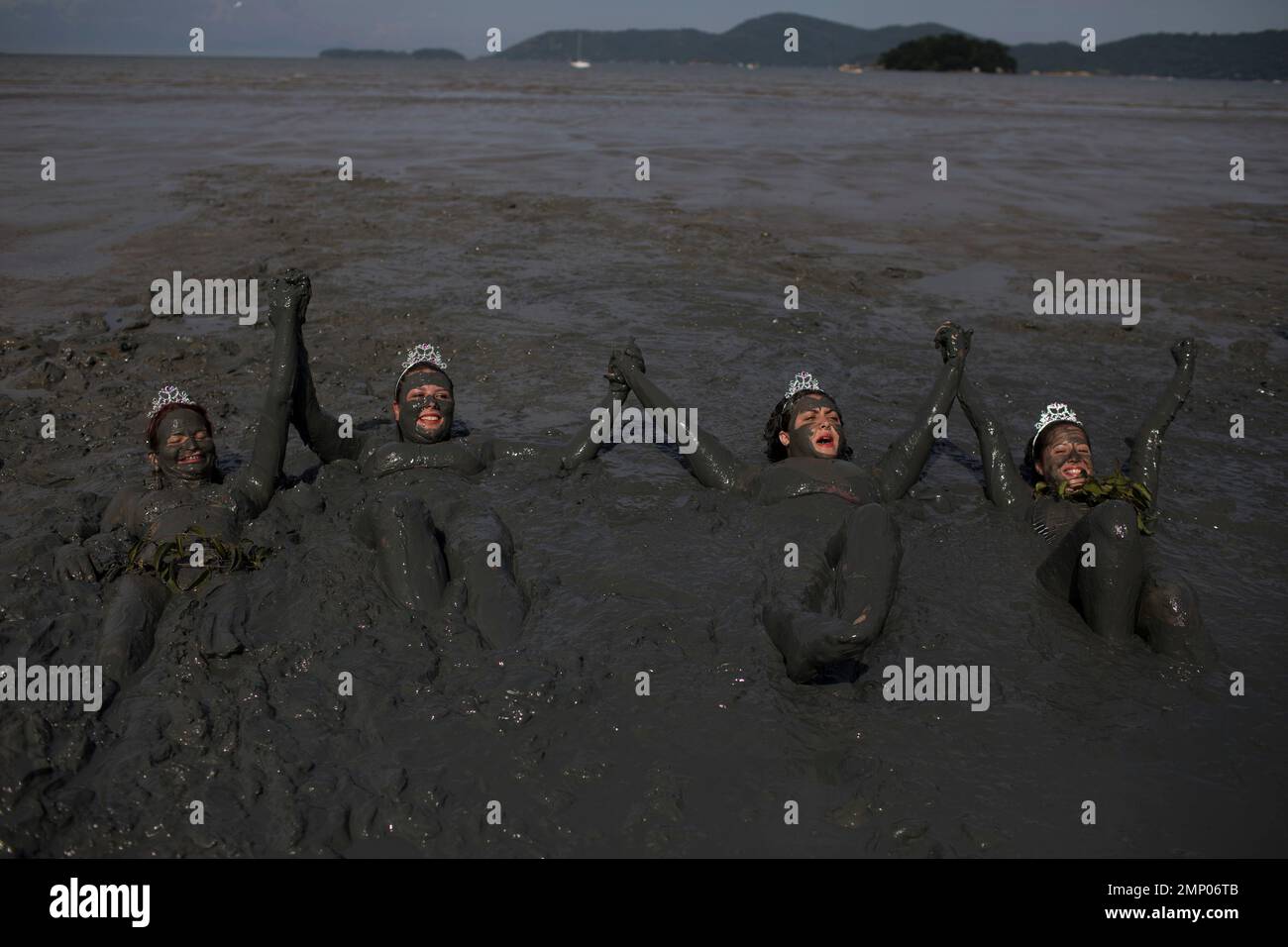 Mud covered revelers play in the mud during the traditional "Bloco da ...