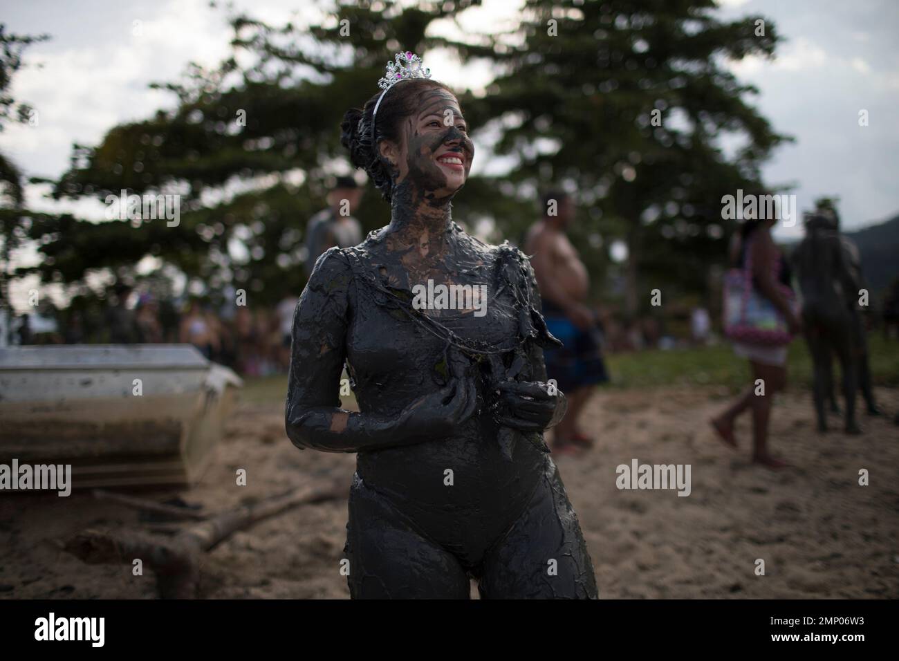 A mud covered woman poses for a picture during the traditional "Bloco ...