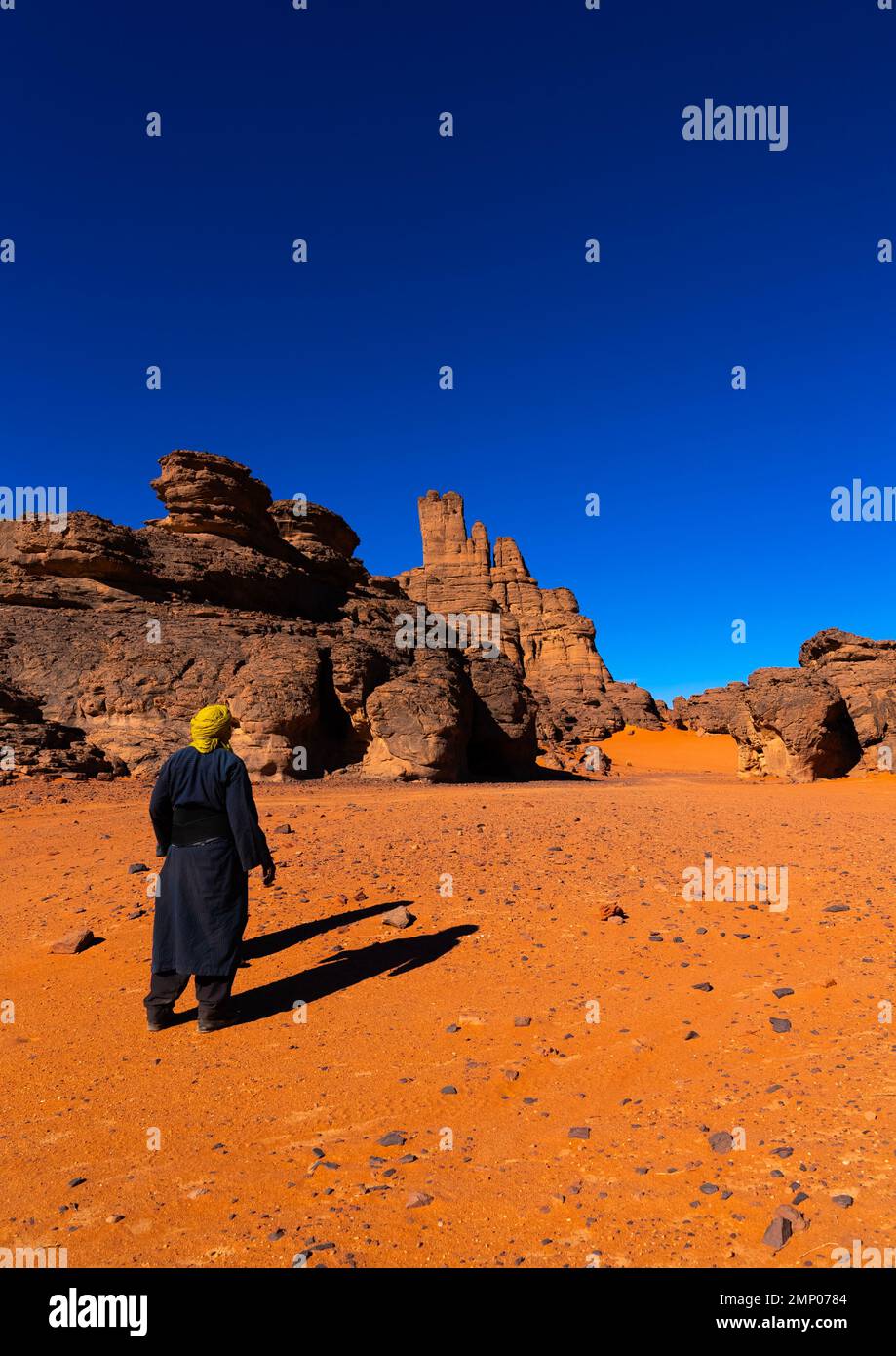 Tuaref in front of rocks and sand dunes in desert, Tassili N'Ajjer ...