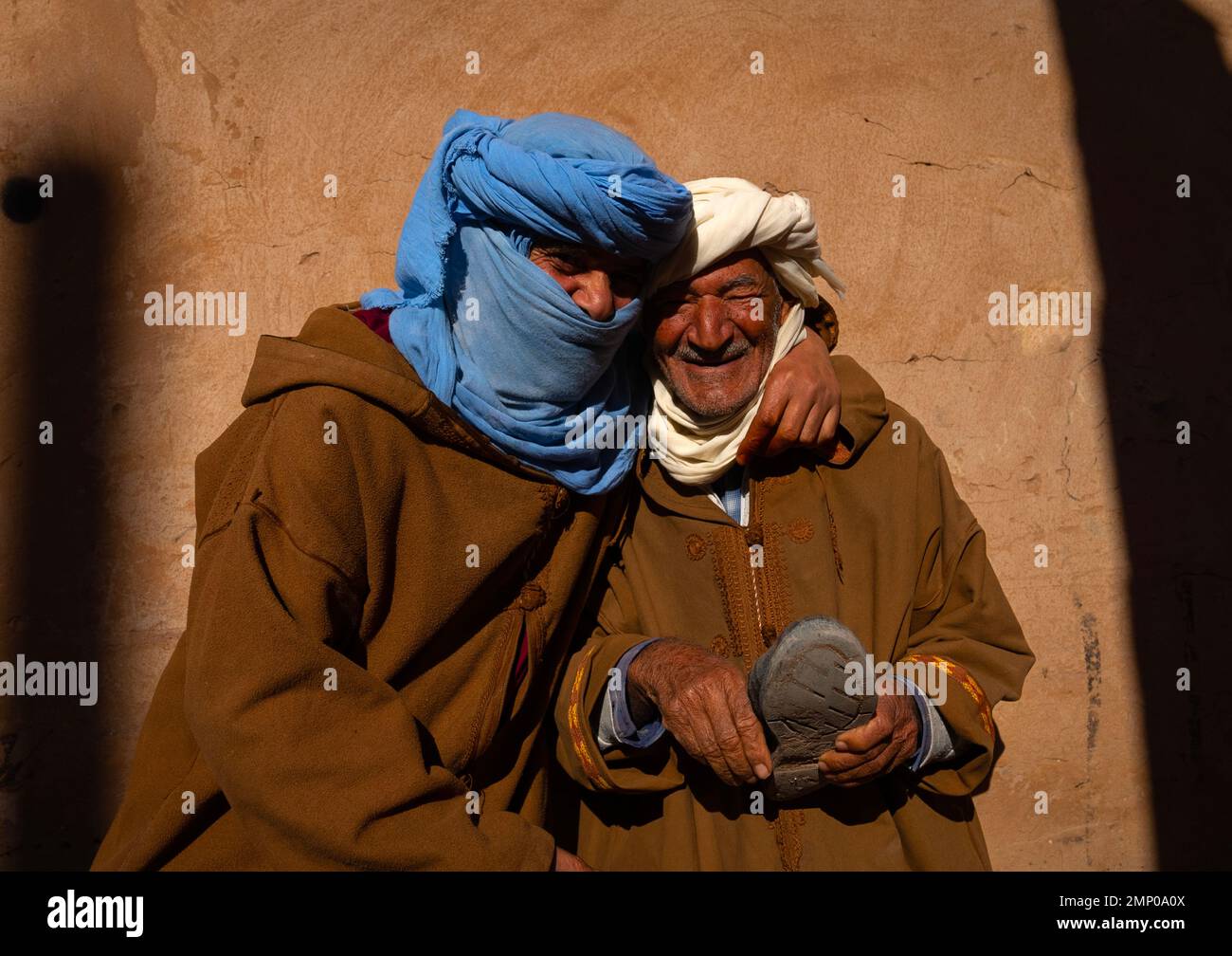 Two men in bournous laughing together in the street, North Africa ...
