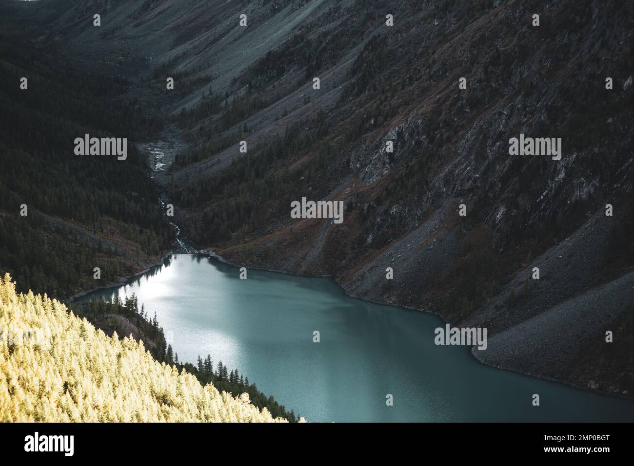 Mountain lake Shavlinskoe in the shade without the sun between the ...