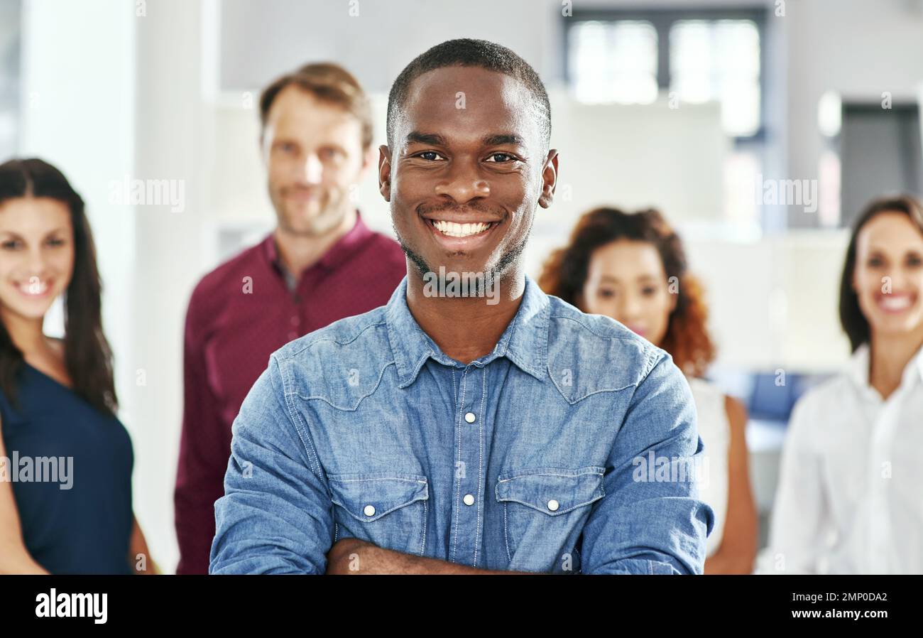 The team that makes things happen. Portrait of a businessman with his coworkers standing behind ...
