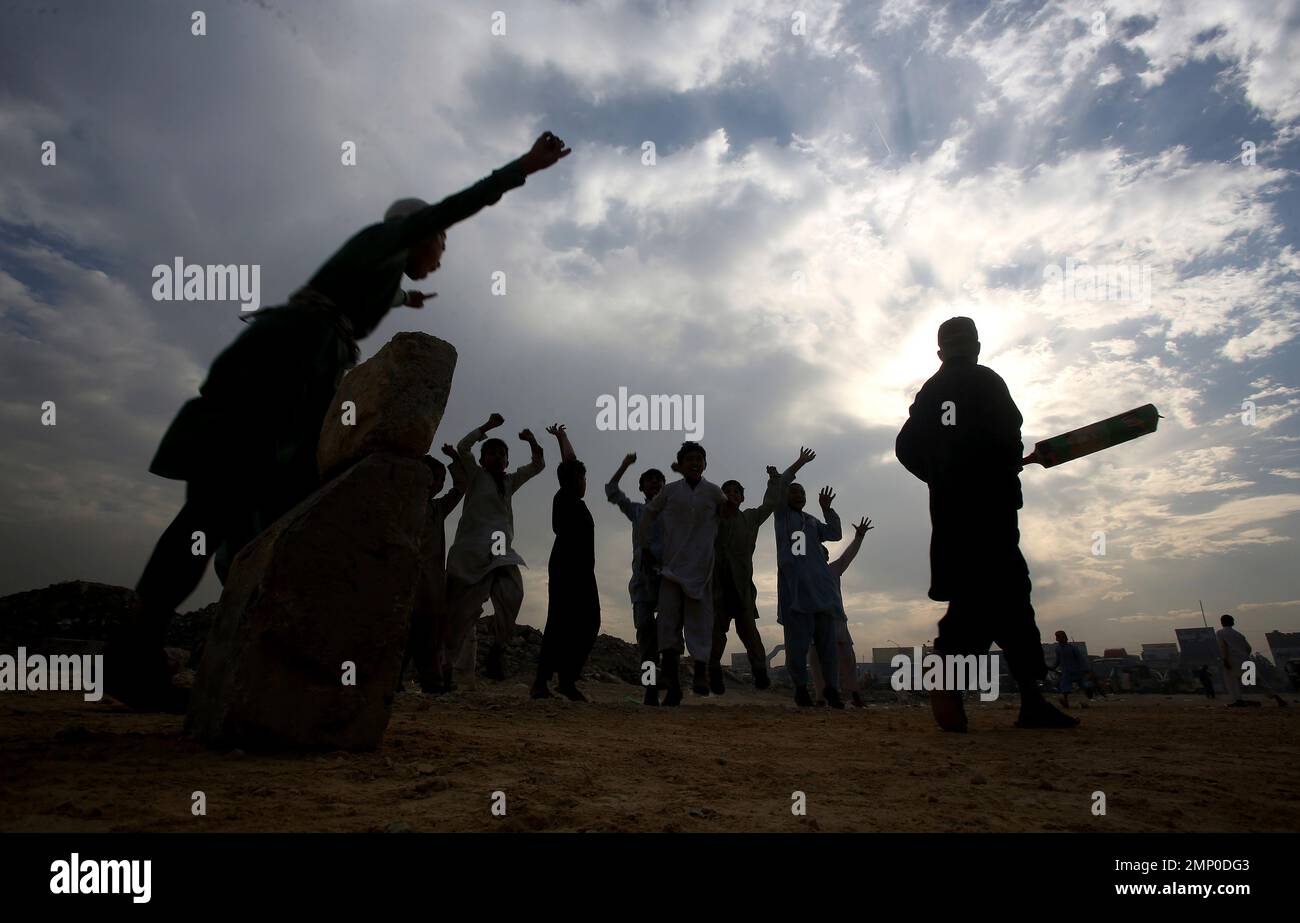 Pakistani children living in slums play cricket in their neighborhood ...