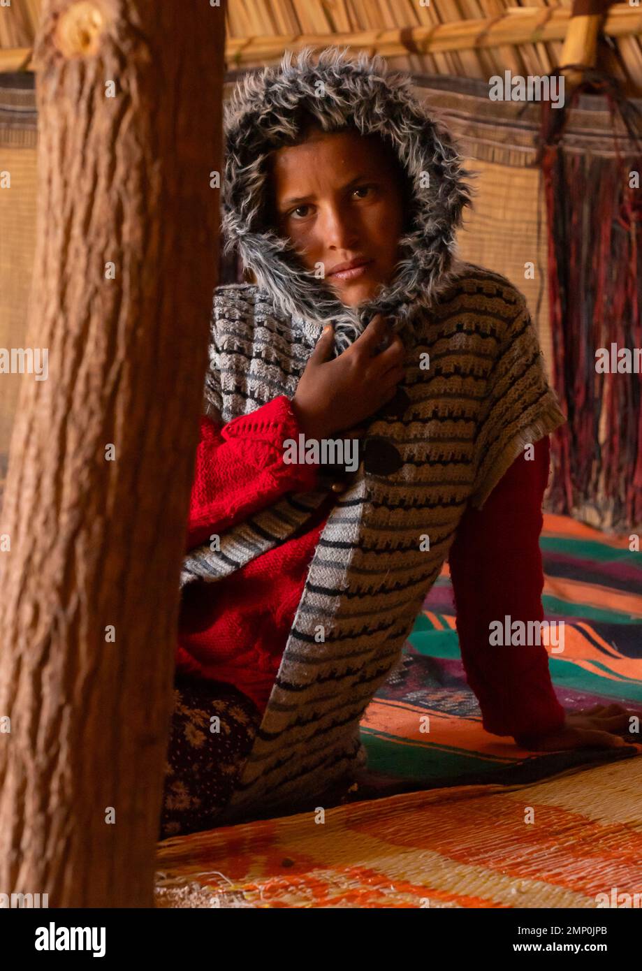 Portrait of a tuareg boy sit inside a reed house, North Africa ...