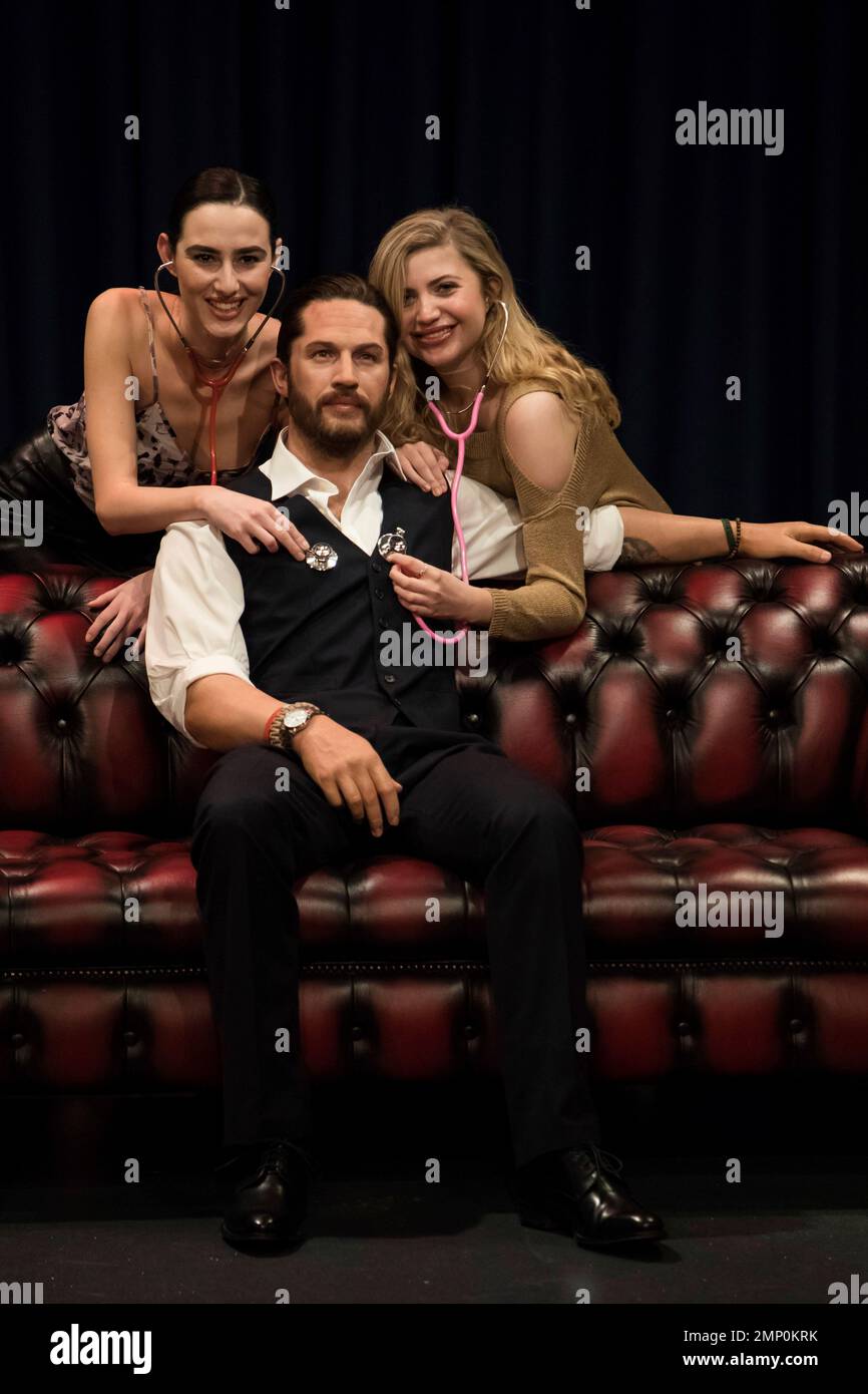 Models xxx, left, and xxx pose with the new wax figure of actor Tom ...