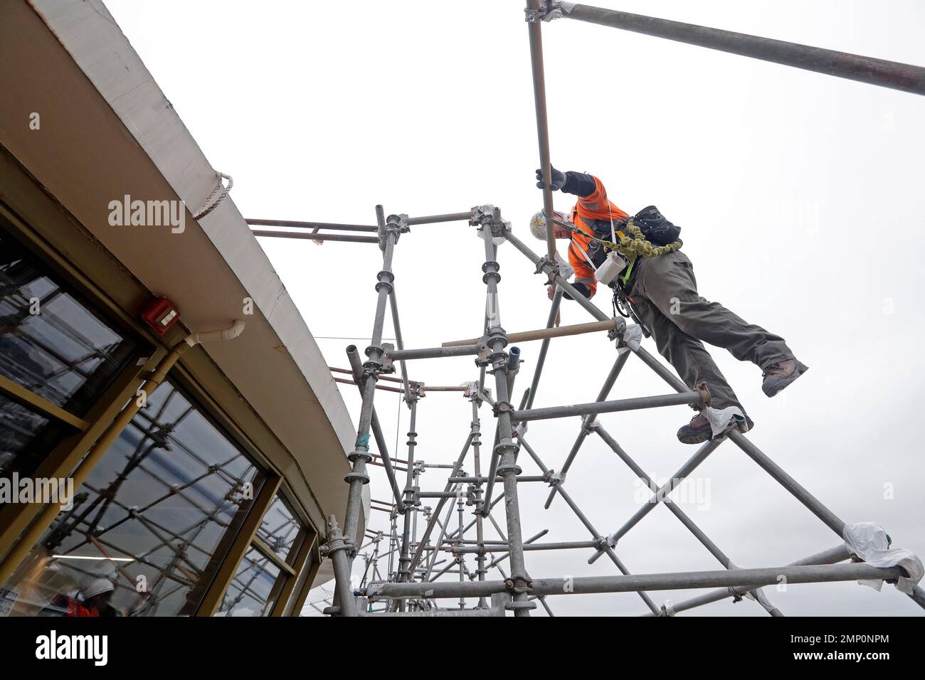Jake Willis climbs out on scaffolding as he builds it on the halo of ...