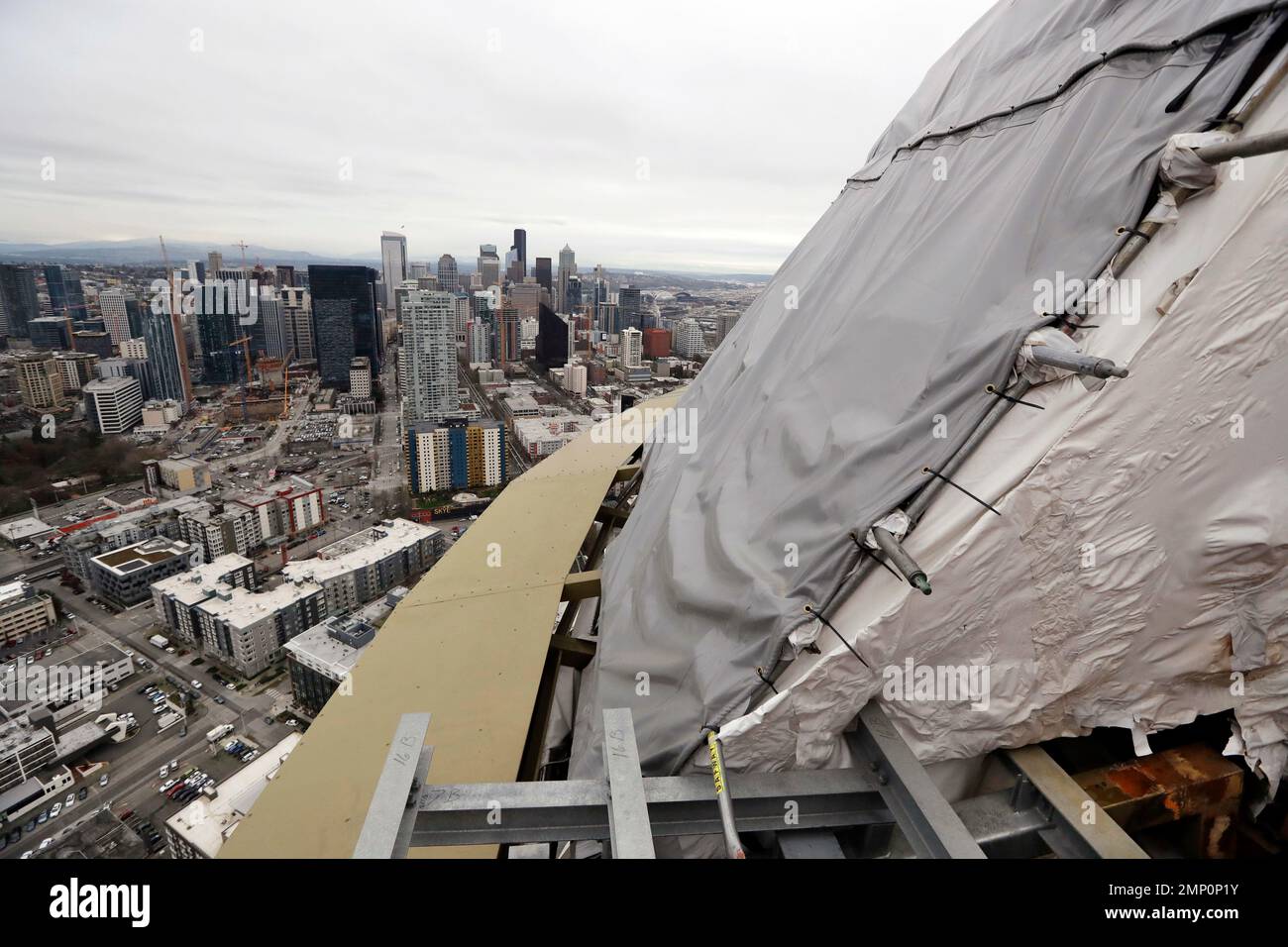 The halo of the Space Needle peeks out from under scaffolding as work ...