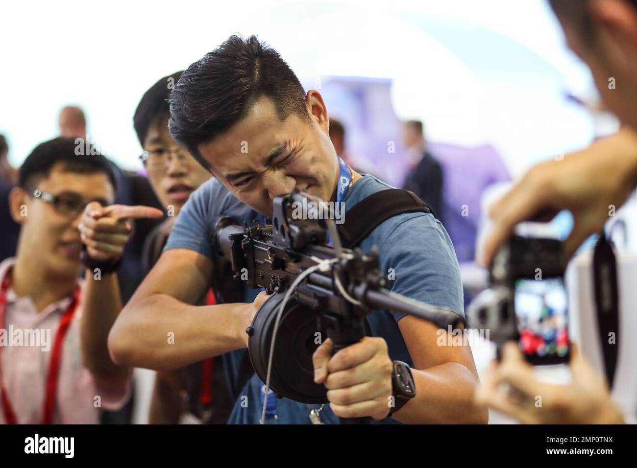 A visitor poses for a photo with the Ultimax 100 Mark 8 light machine ...