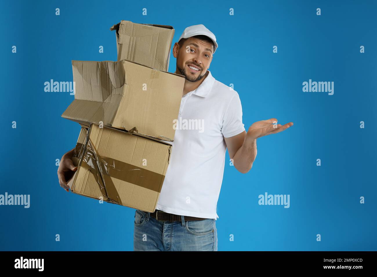 Emotional courier with damaged cardboard boxes on blue background. Poor ...