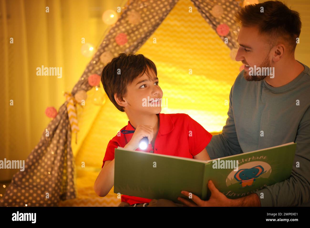 Father and son with flashlight reading book at home Stock Photo - Alamy