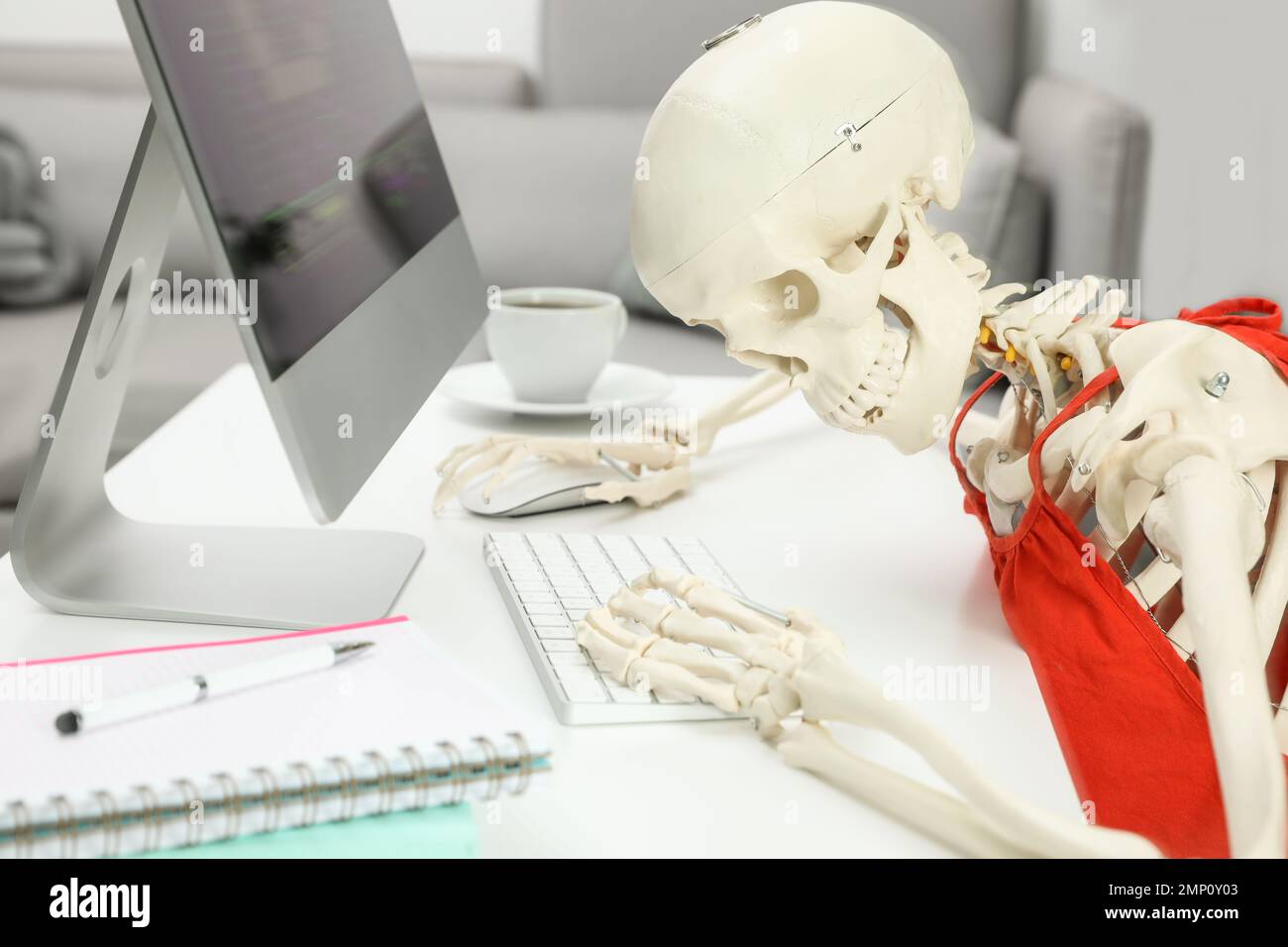 Human skeleton in red dress using computer at table Stock Photo - Alamy