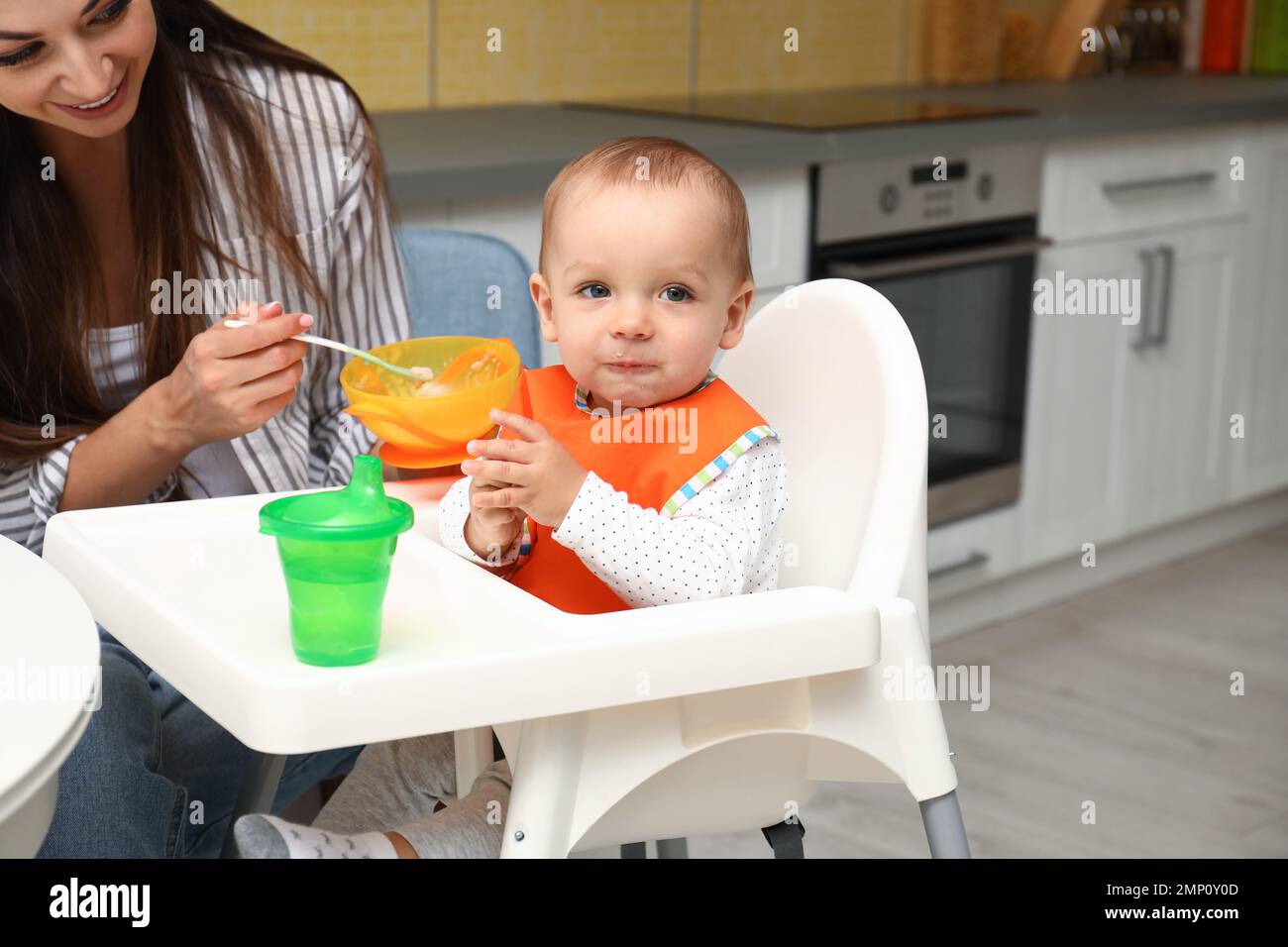 Young mother feeding her little baby at home Stock Photo - Alamy