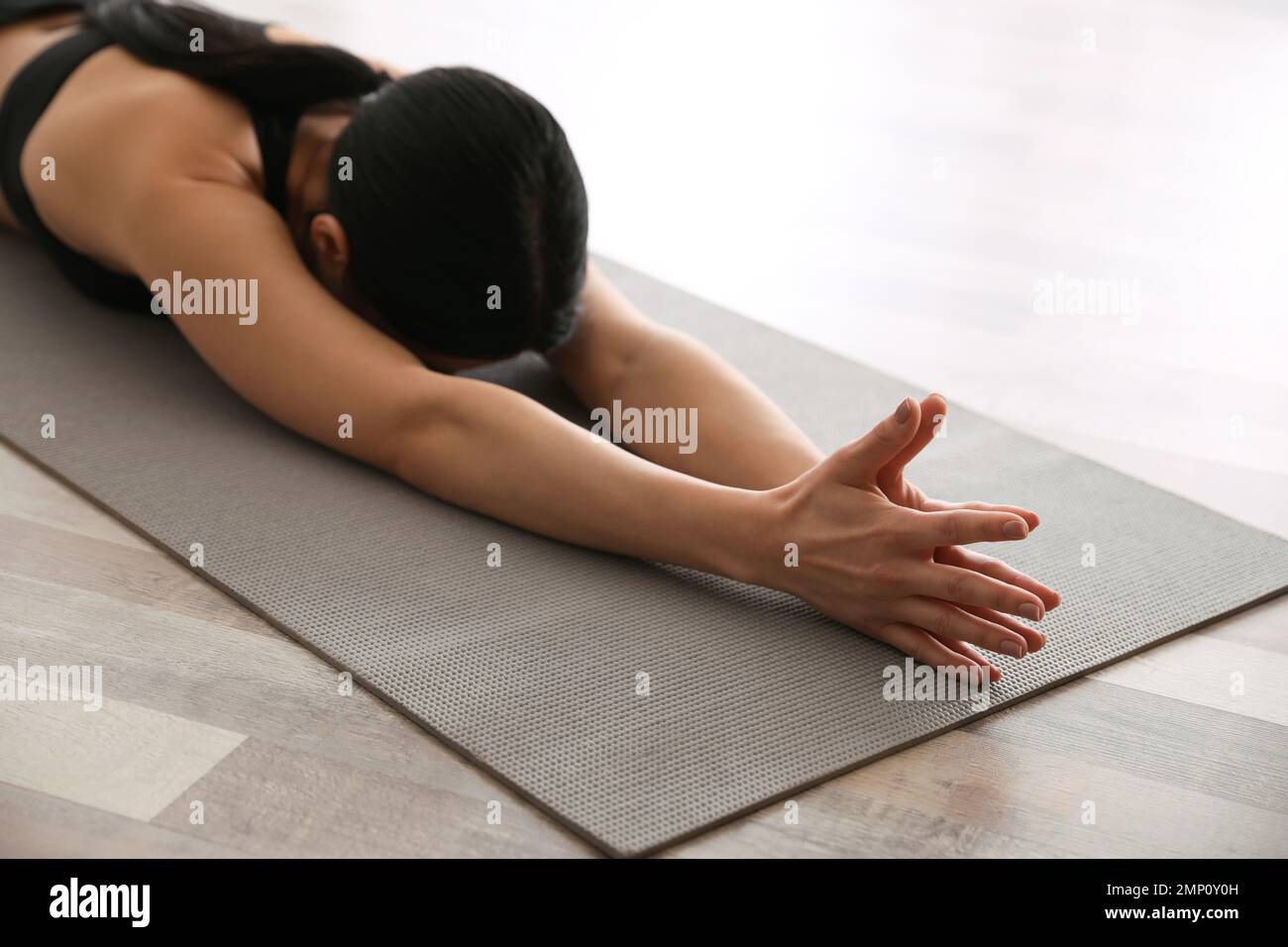 Young woman practicing extended child's asana in yoga studio, closeup ...