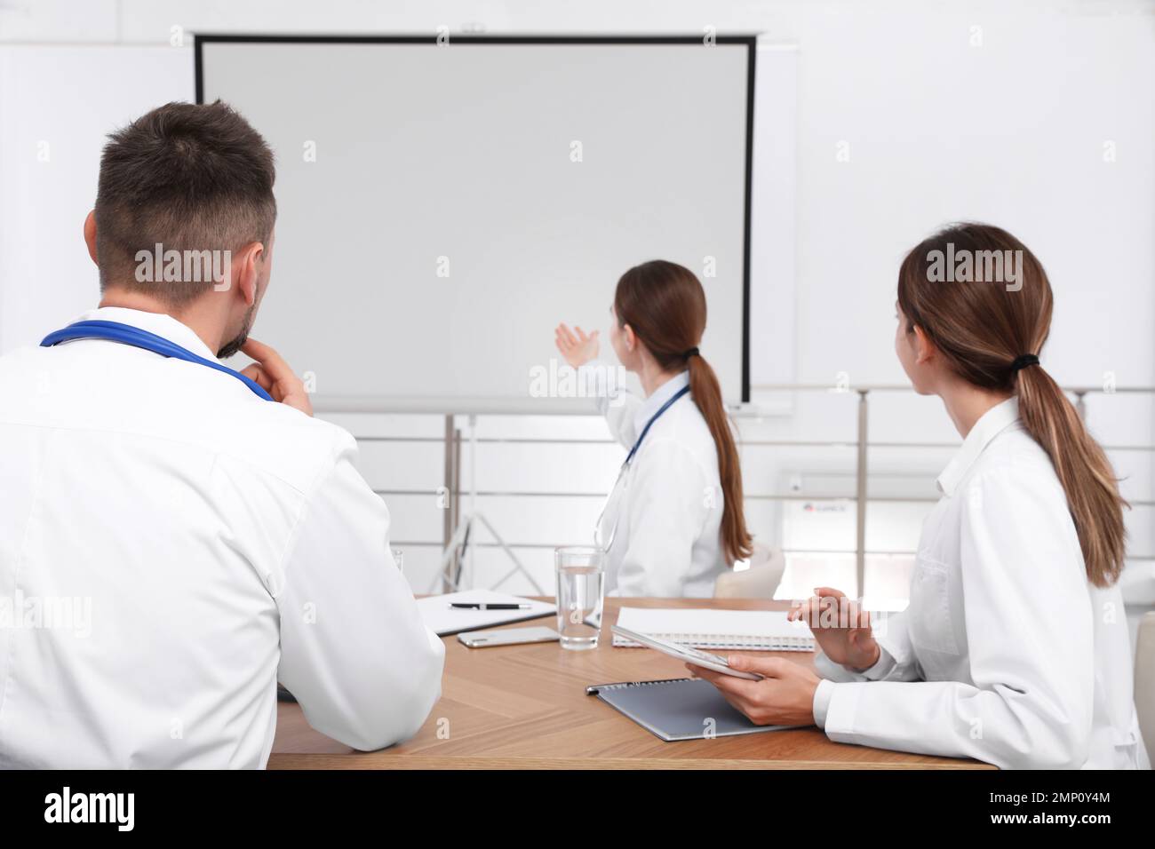 Team of doctors looking at projection screen indoors Stock Photo - Alamy