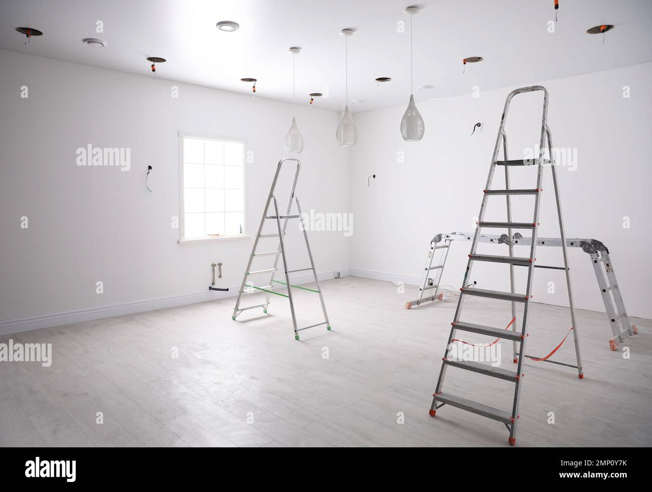 Empty room with stretch ceiling and ladders Stock Photo - Alamy