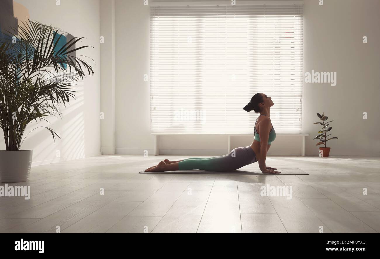 Woman practicing cobra asana in yoga studio. Bhujangasana pose Stock ...