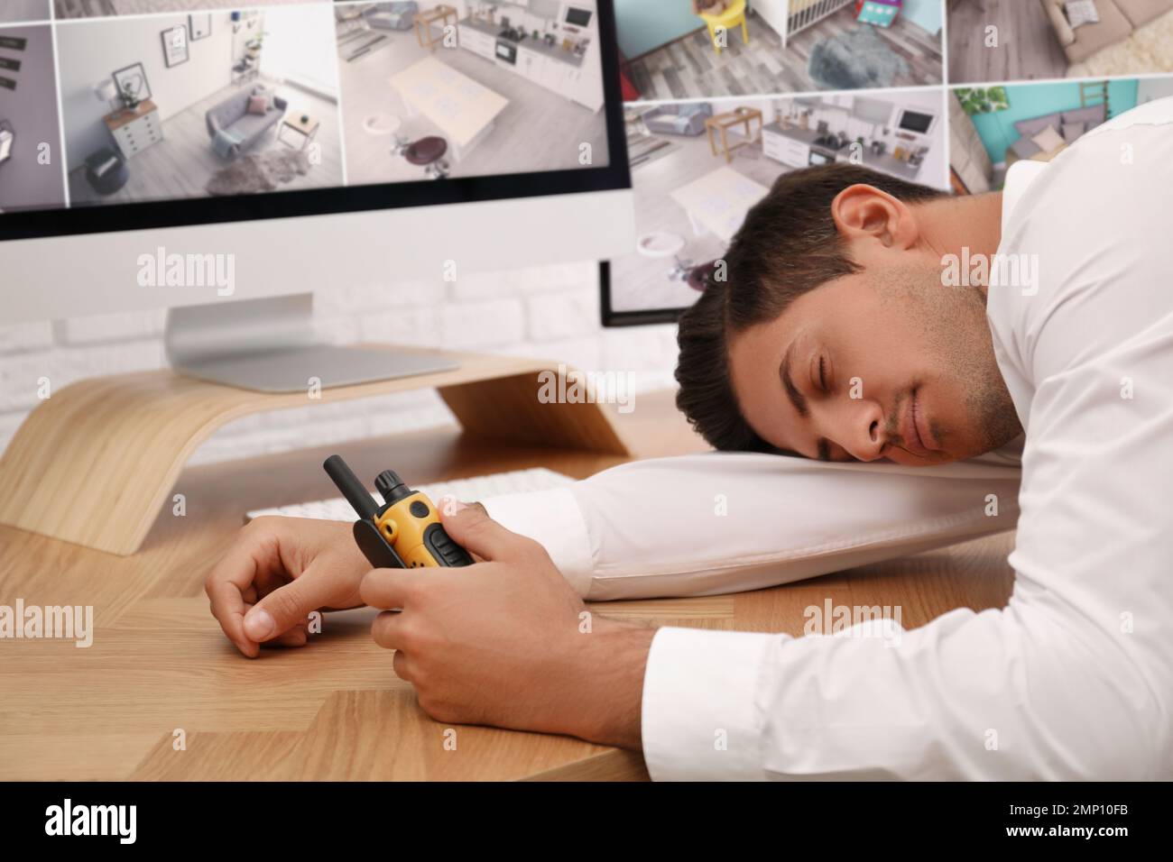 Male security guard sleeping near monitors at workplace Stock Photo - Alamy