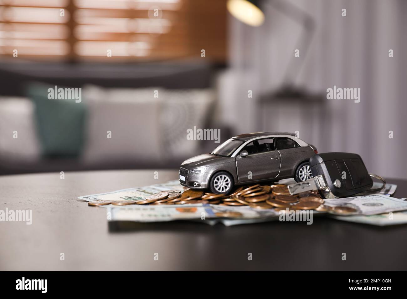 Miniature automobile model, key and money on table indoors. Car buying ...