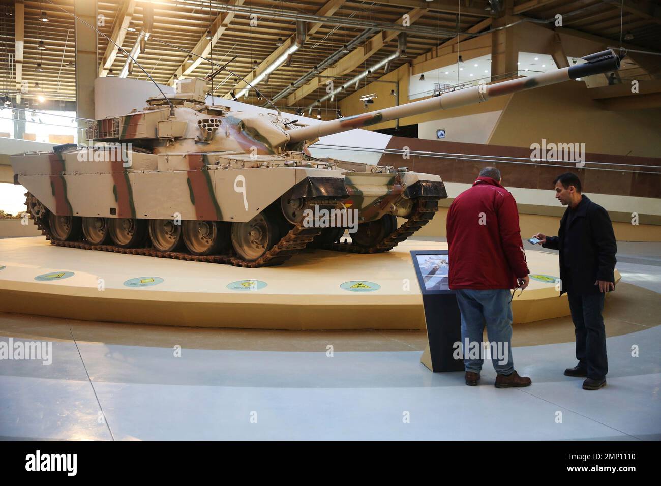 Two men read a display of a tank at the Royal Tank Museum in Amman ...