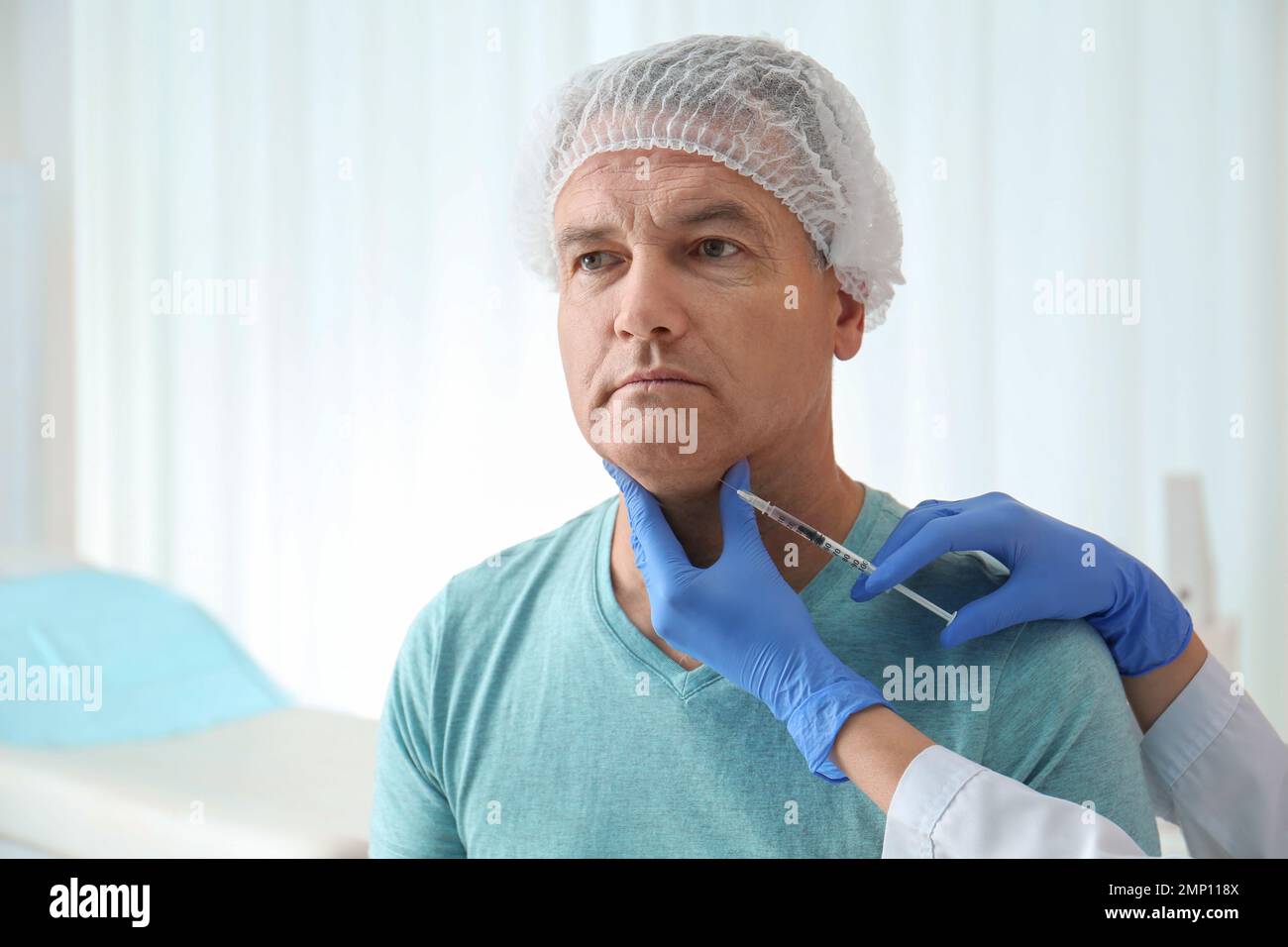 Mature man with double chin receiving injection in clinic Stock Photo ...