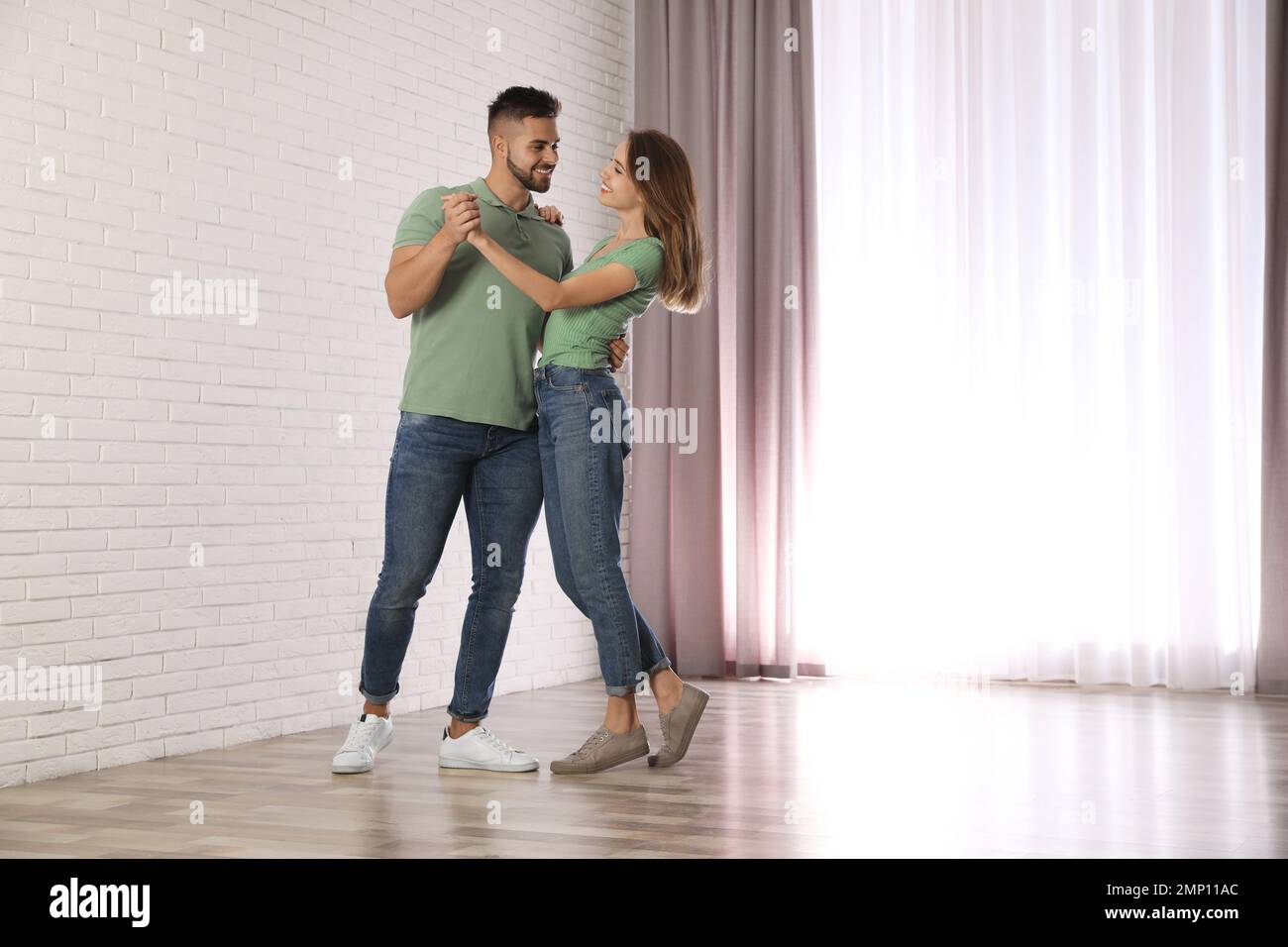 Lovely young couple dancing together at home Stock Photo - Alamy