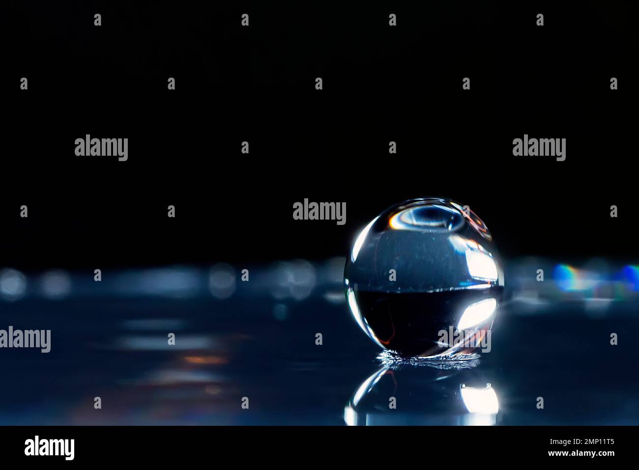 frozen instant in which the falling drop enters the liquid. Foreground ...