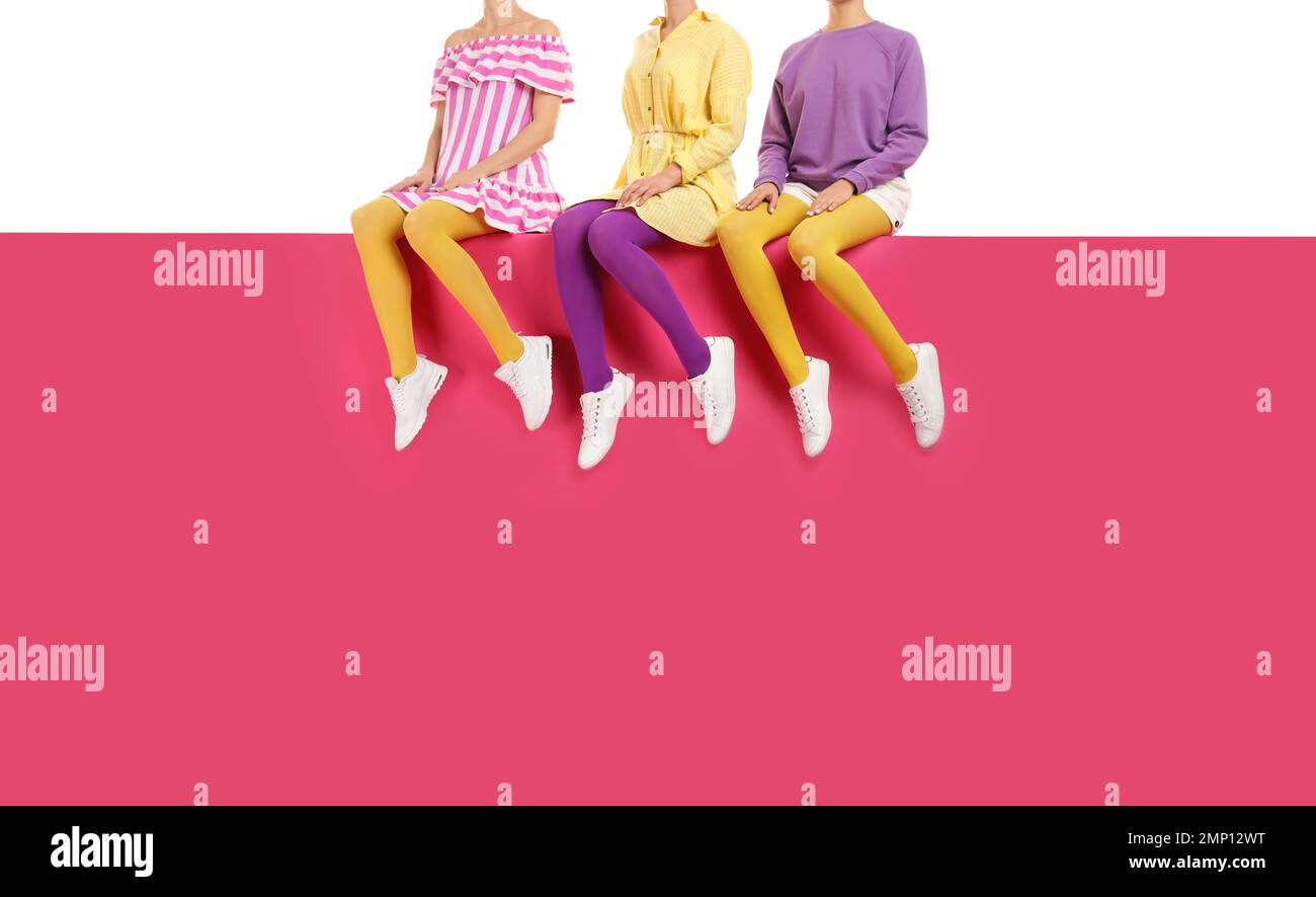 Group of women wearing bright tights and stylish shoes sitting on color ...
