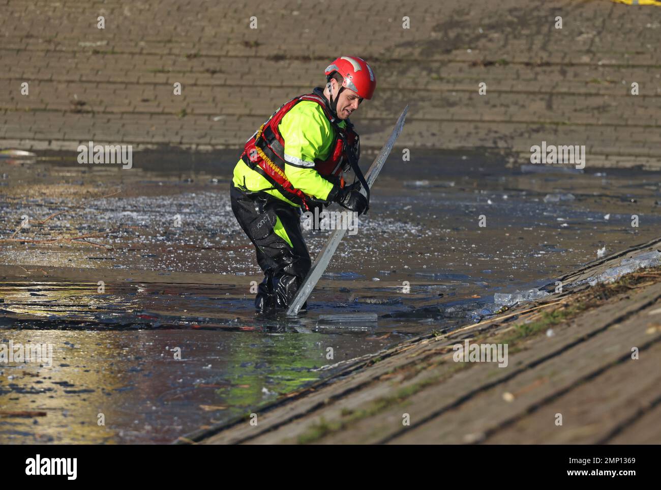 A firefighter shows how thick the ice is as fire and rescue crews from ...