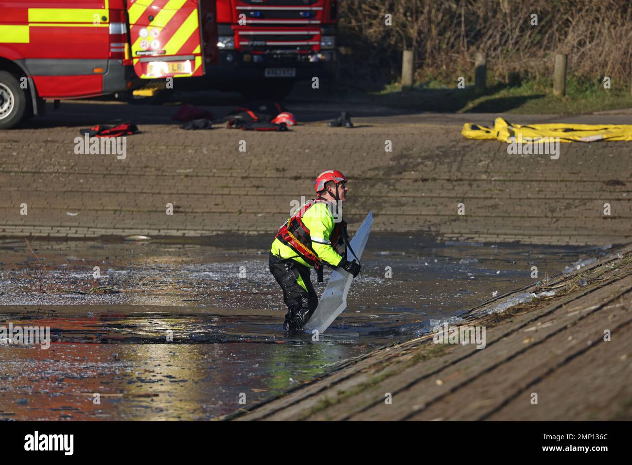 A firefighter shows how thick the ice is as fire and rescue crews from ...