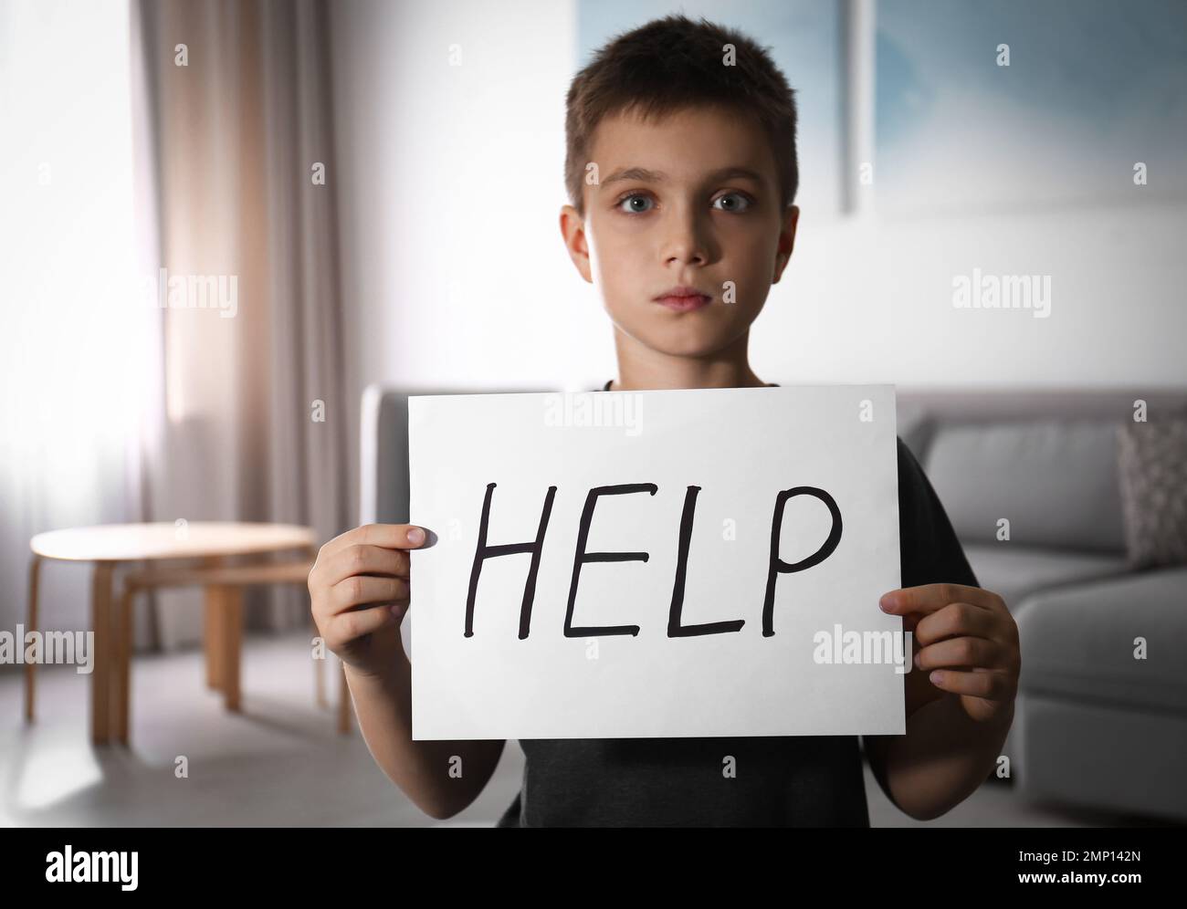 Abused little boy with sign HELP indoors. Domestic violence concept ...
