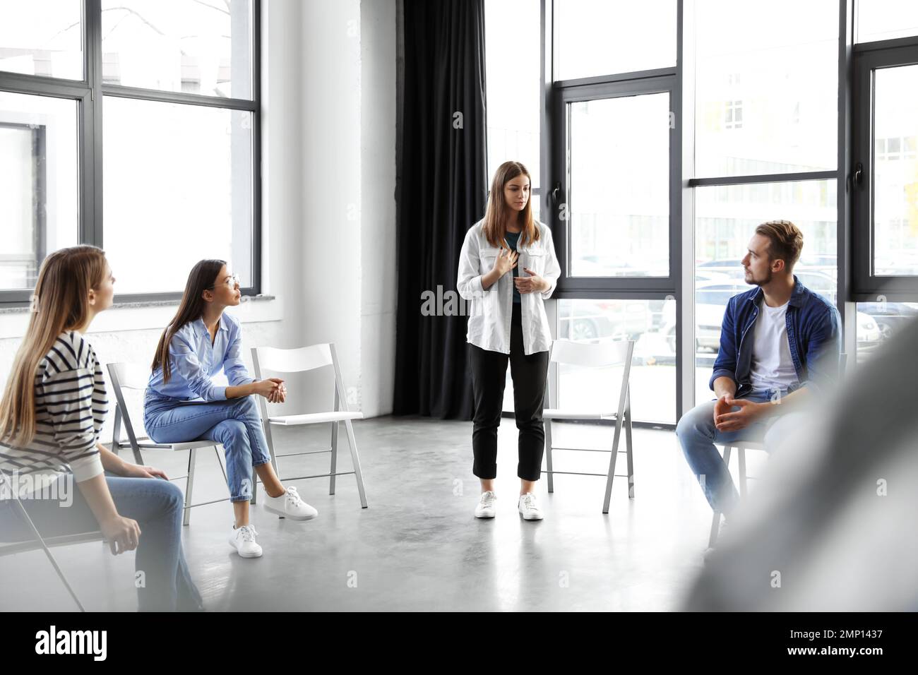 Psychotherapist working with patients in group therapy session indoors ...