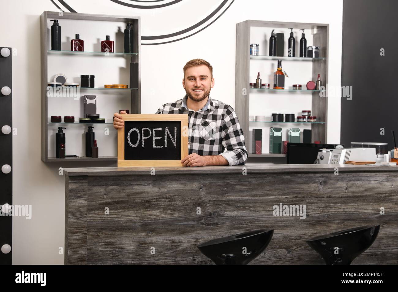 Young business owner holding OPEN sign in his barber shop Stock Photo ...