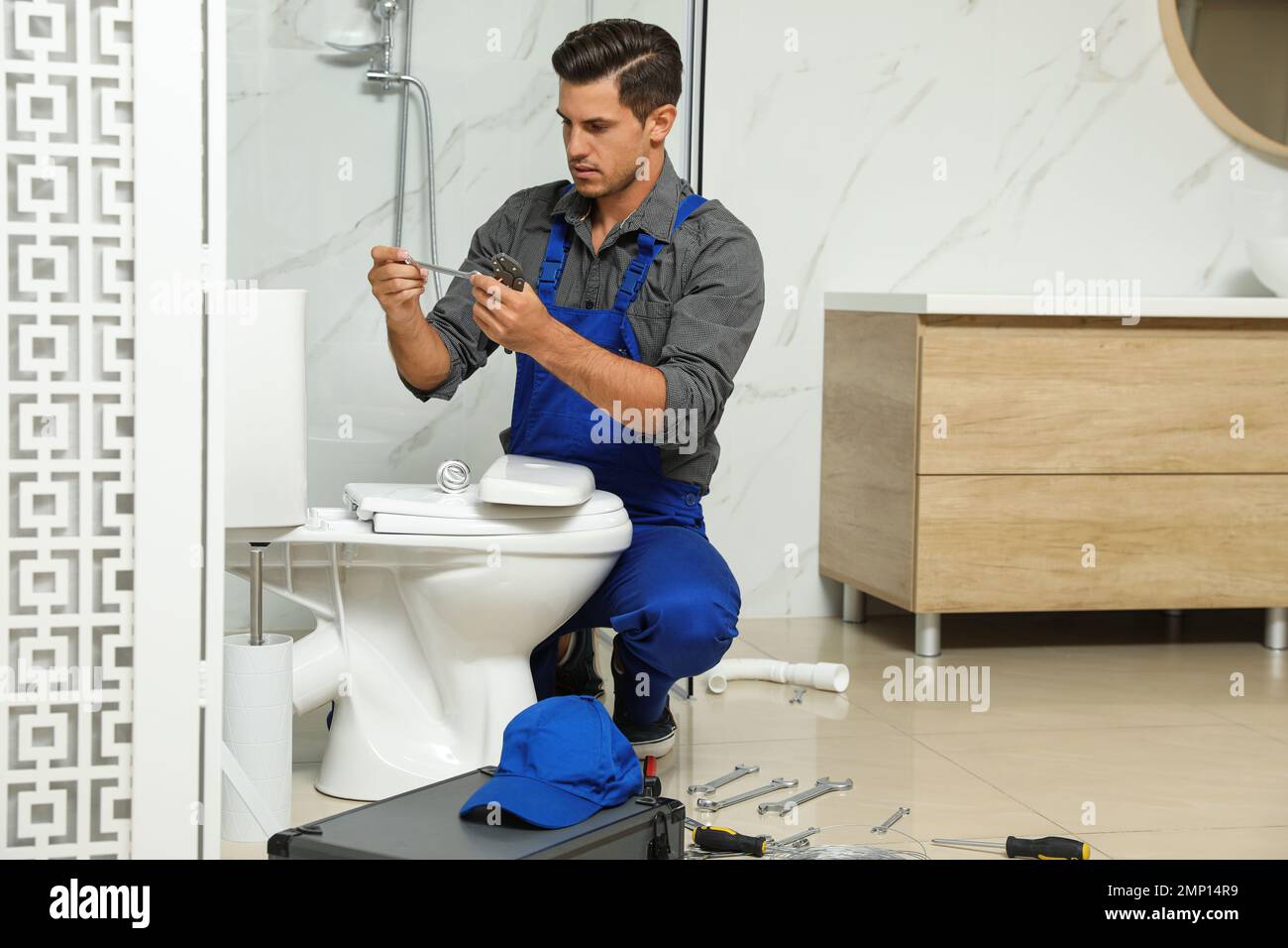 Professional plumber working with toilet bowl in bathroom Stock Photo ...