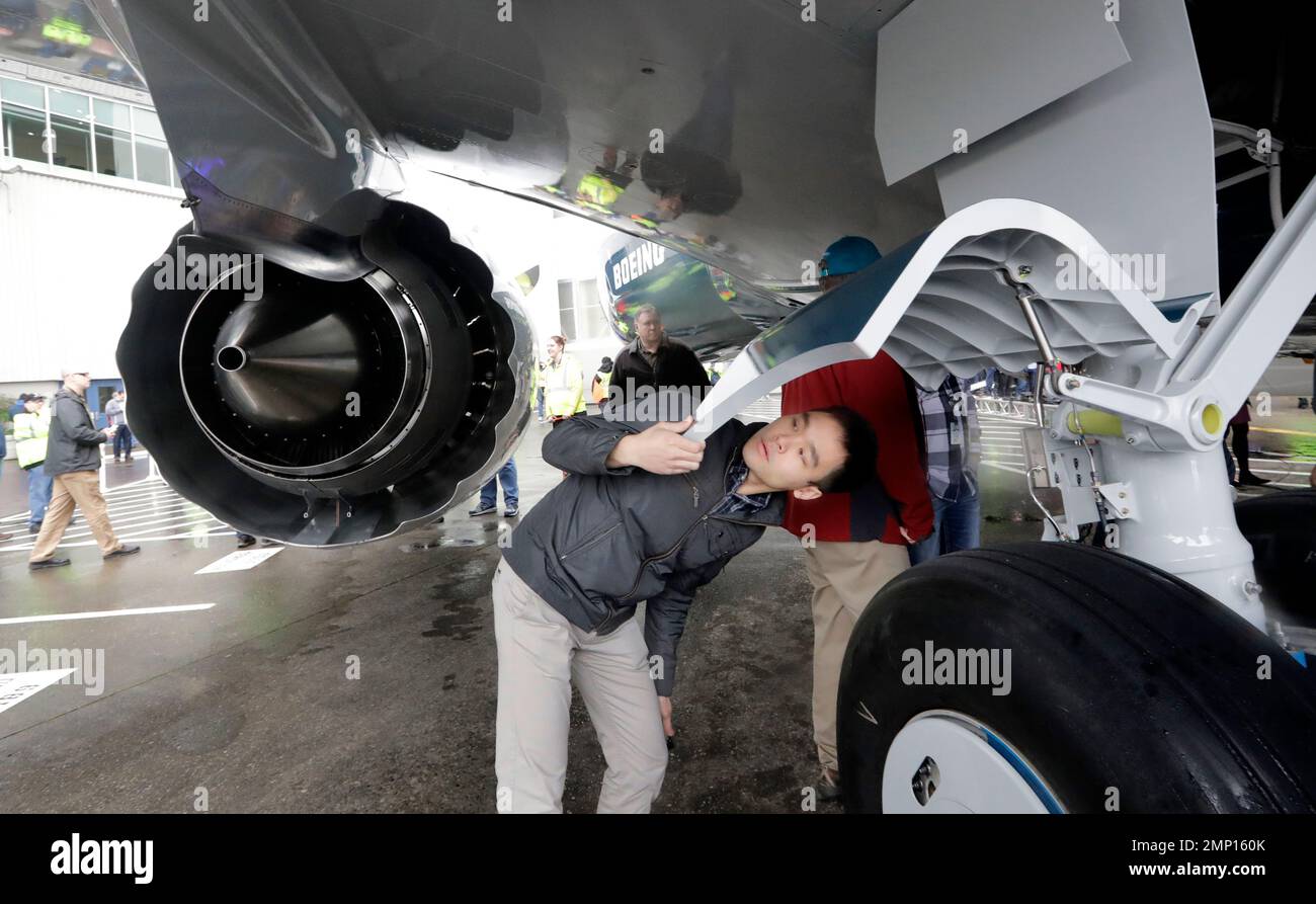 Boeing worker Alex Chang looks under a wheel well cover on a Boeing 737 ...