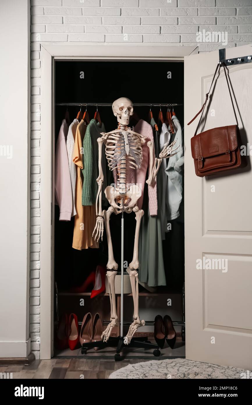 Artificial human skeleton model among clothes in wardrobe room Stock ...